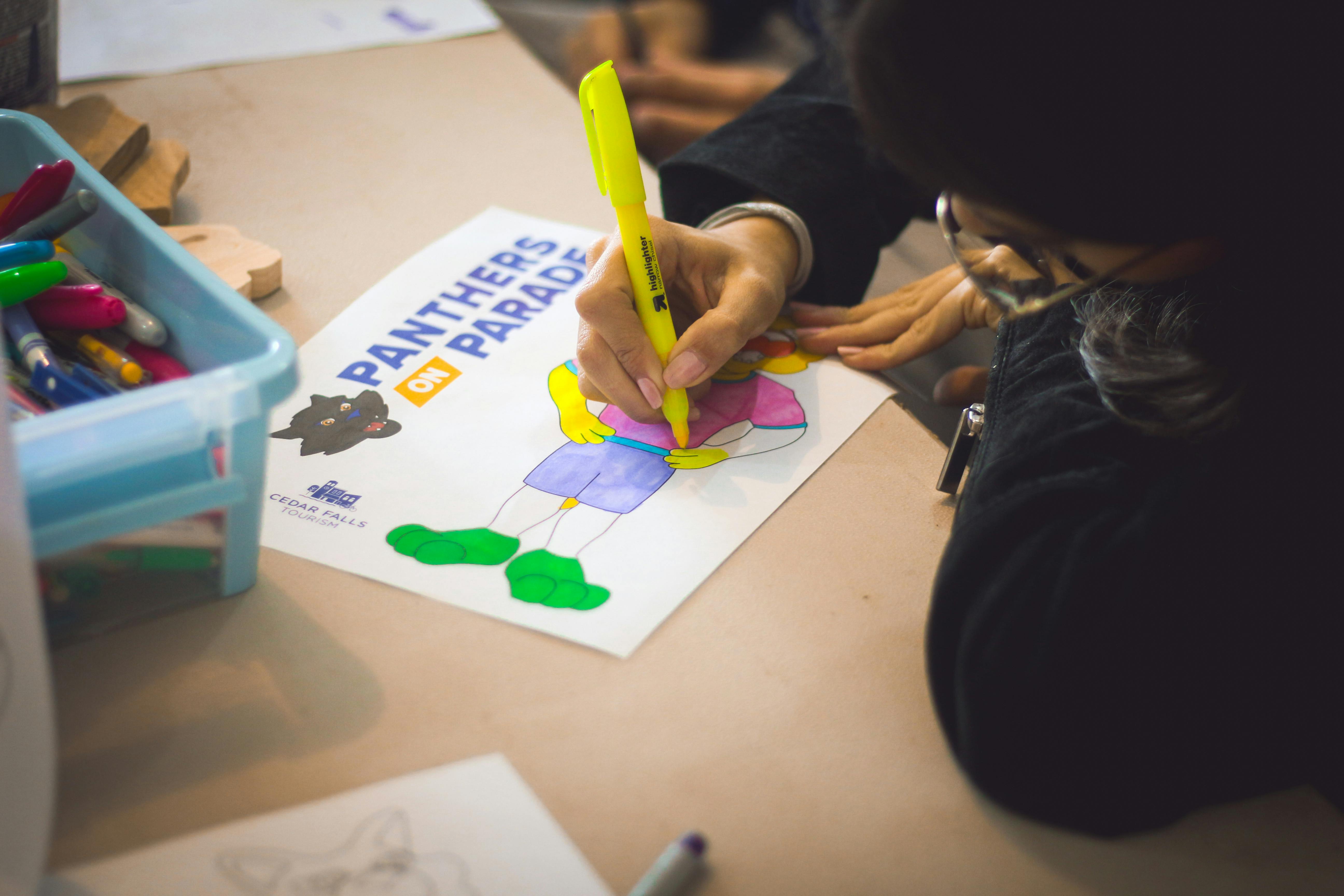 Child Coloring Sheet with Markers on Desk · Free Stock Photo