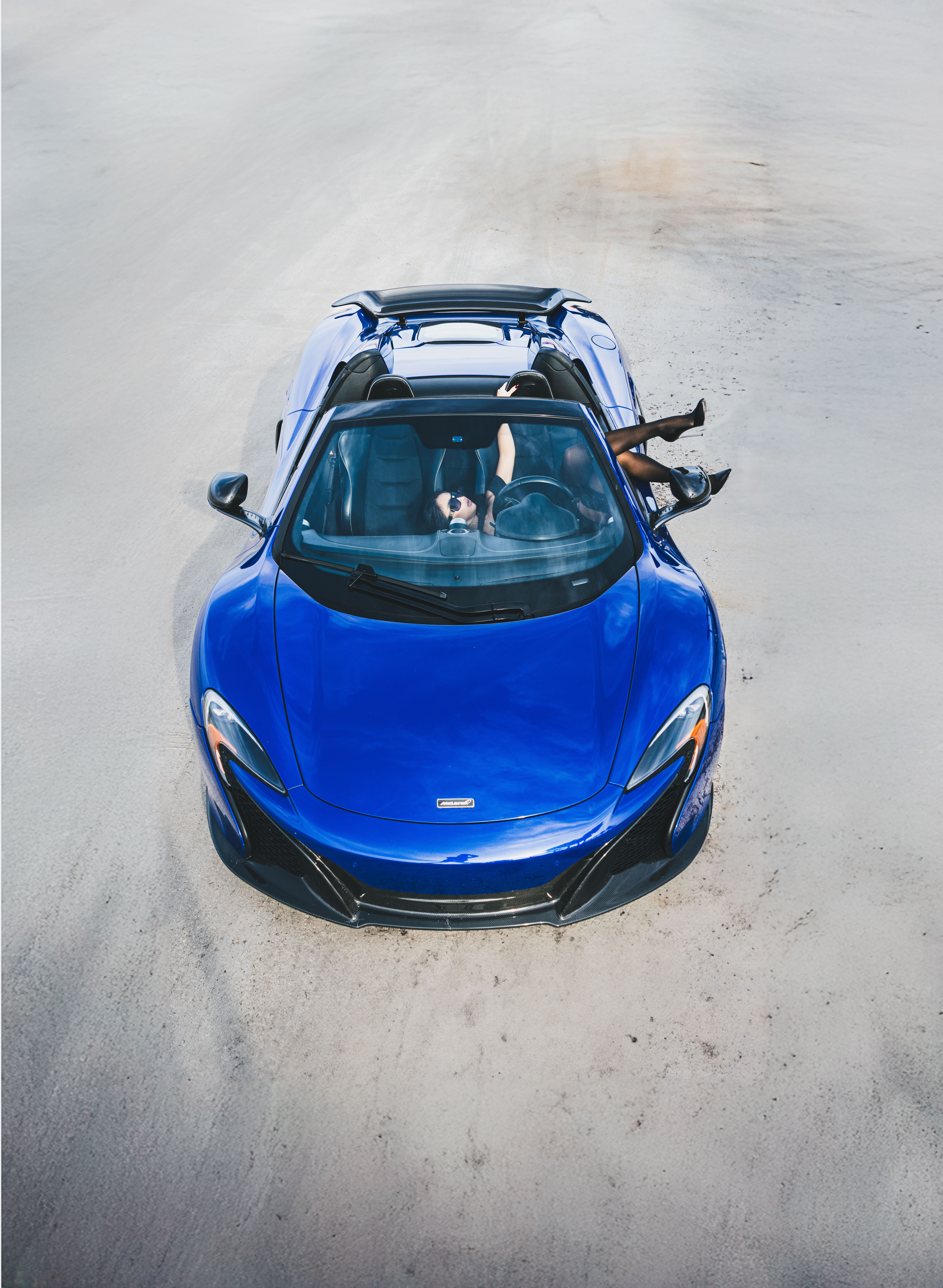 Luxury Sports Car with Legs Relaxing on Sandy Beach · Free Stock Photo
