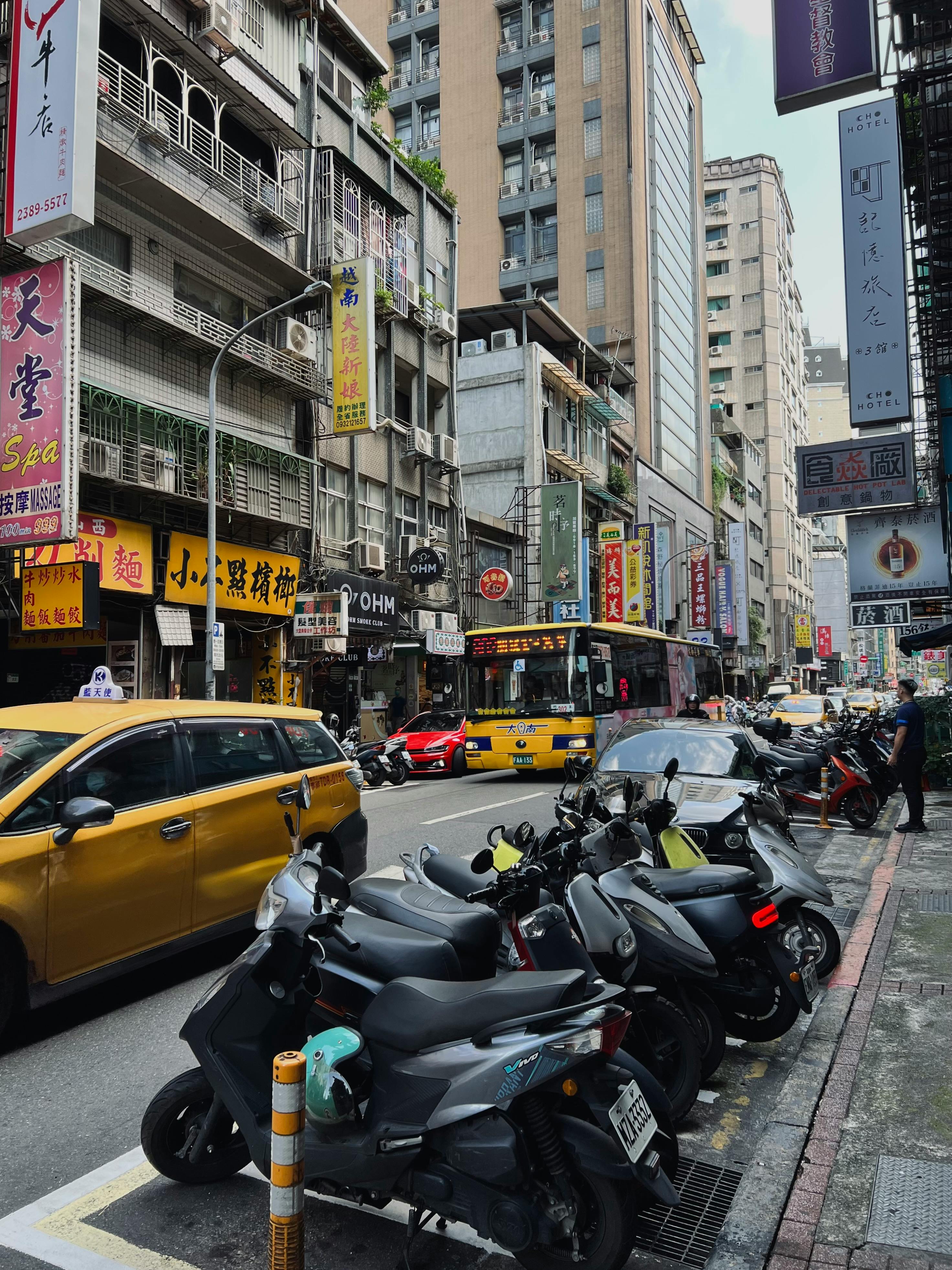 Busy Taipei Street with Motorcycles and Signs · Free Stock Photo