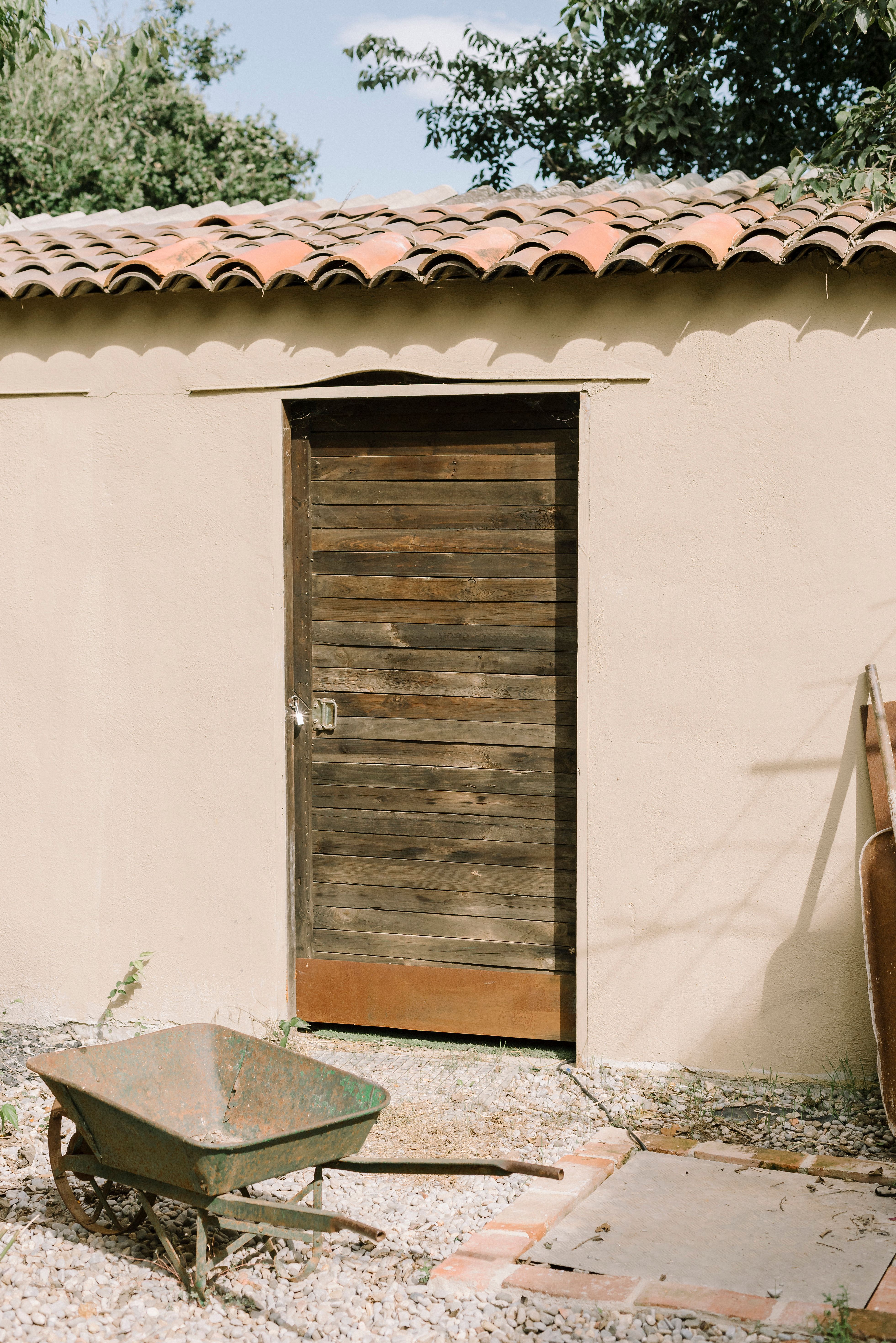 Rustic Wooden Shed Door with Wheelbarrow · Free Stock Photo