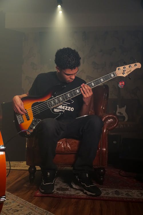 Young Musician Playing Electric Bass Guitar Indoors · Free Stock Photo Young Musician Playing Electric Bass Guitar Indoors · Free Stock Photo