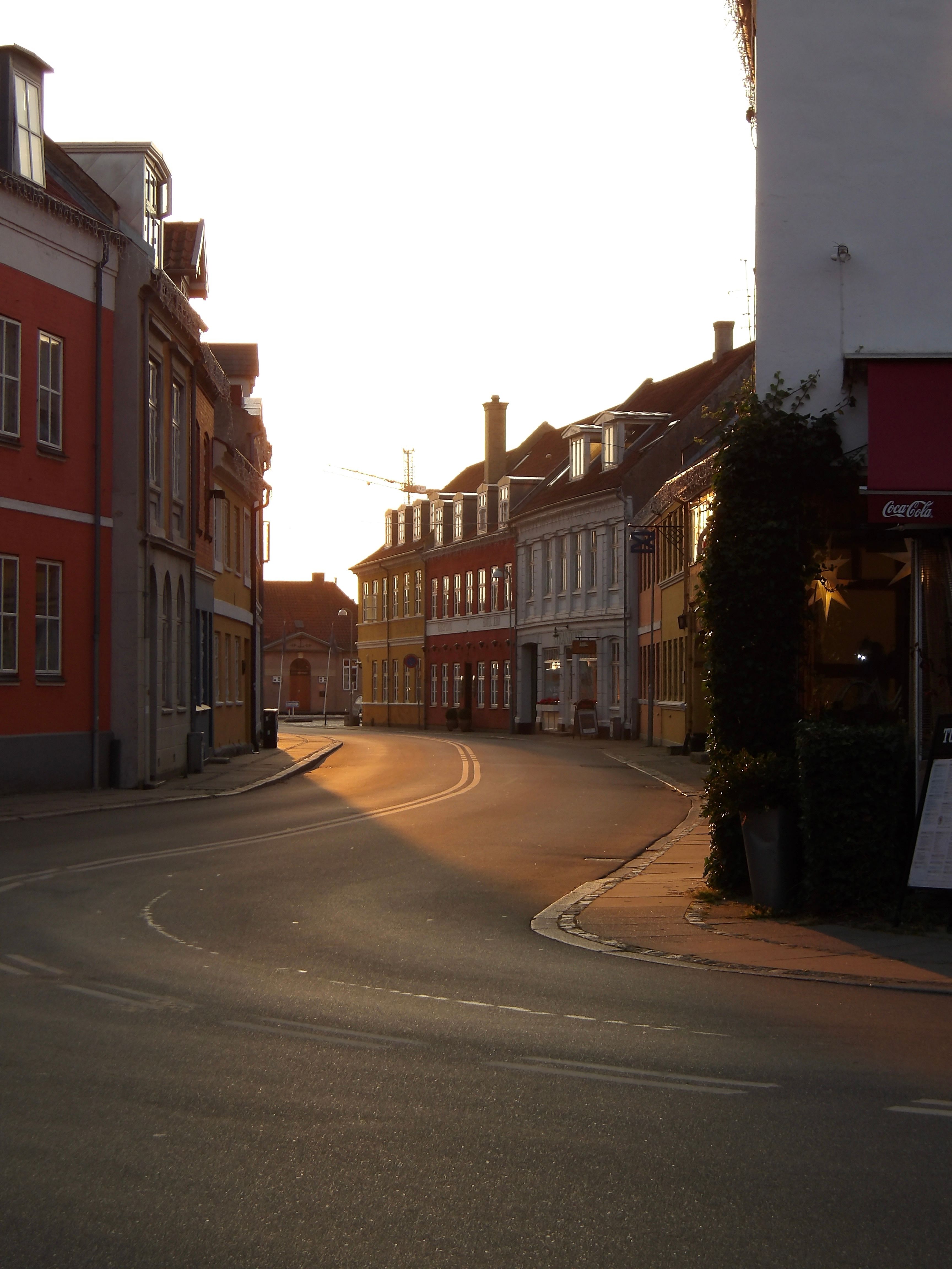 Sunlit European street with colorful houses · Free Stock Photo