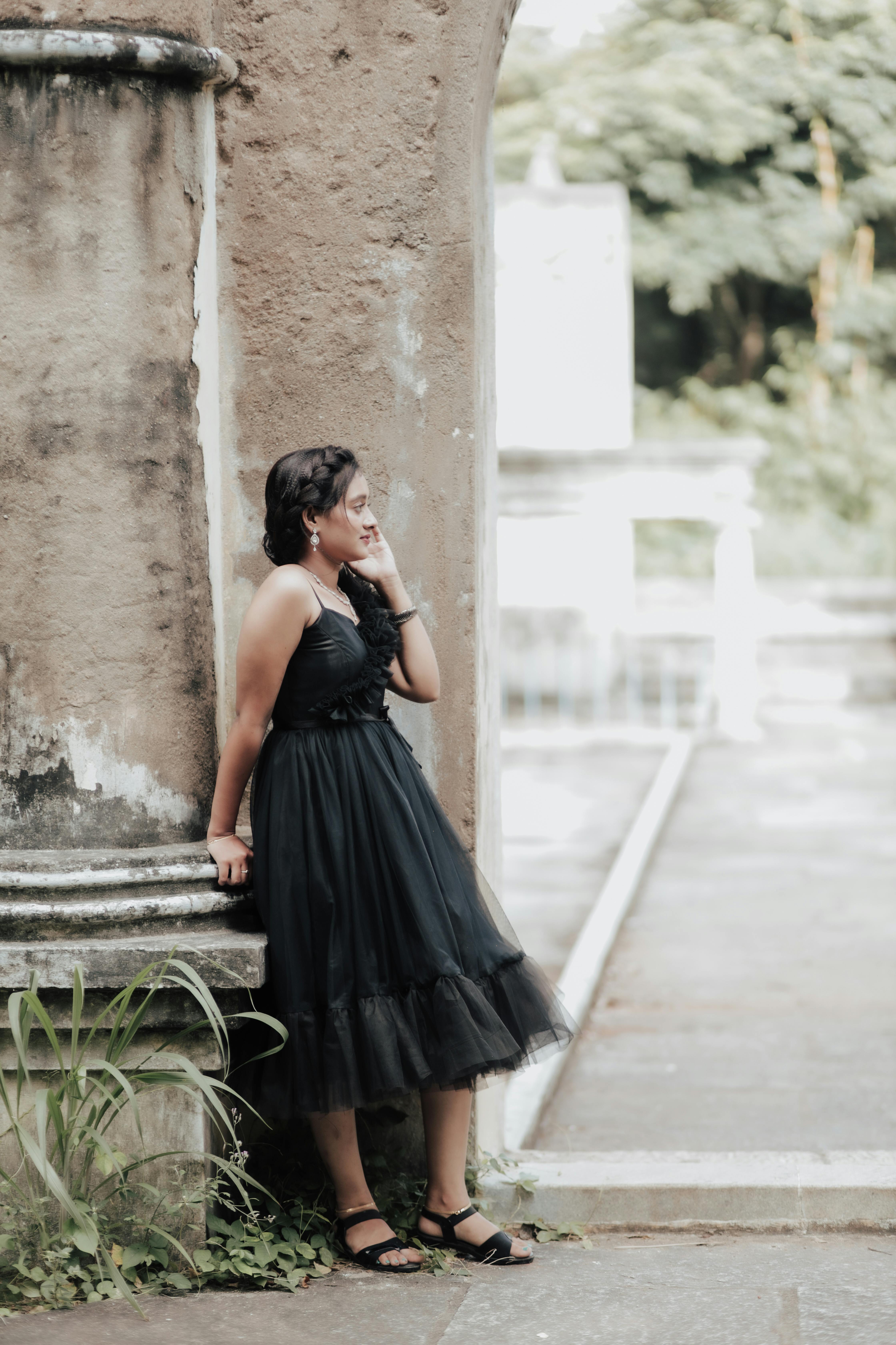 Contemplative Woman by Historic Stone Wall · Free Stock Photo