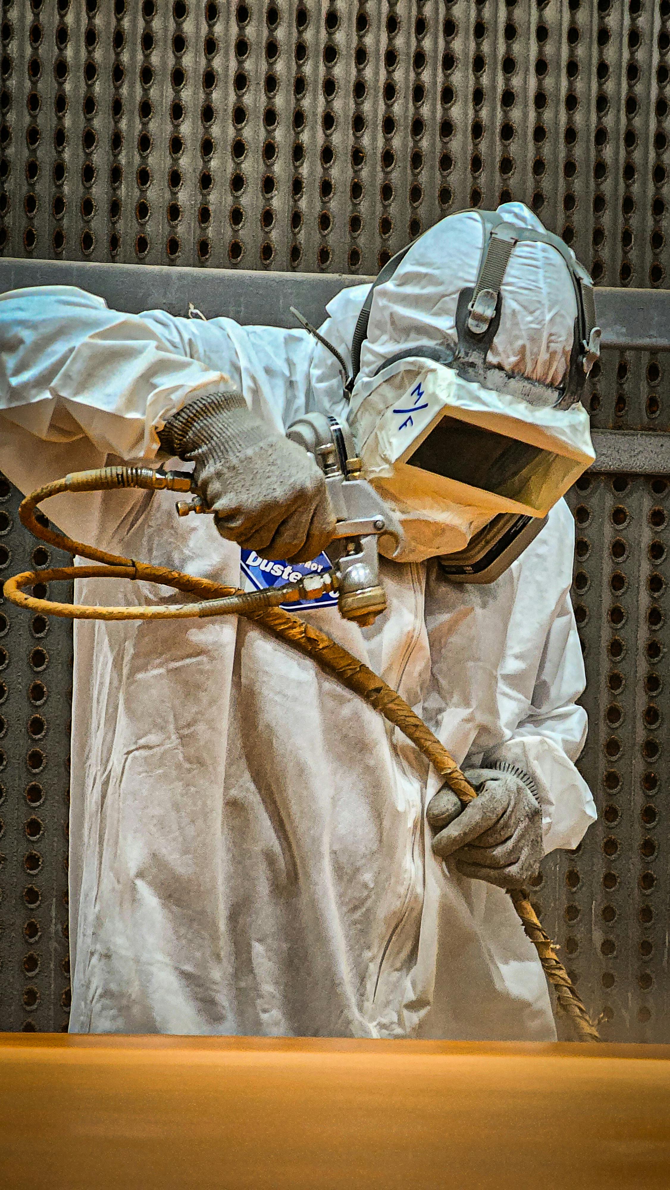 Industrial Worker Sandblasting in Protective Gear · Free Stock Photo