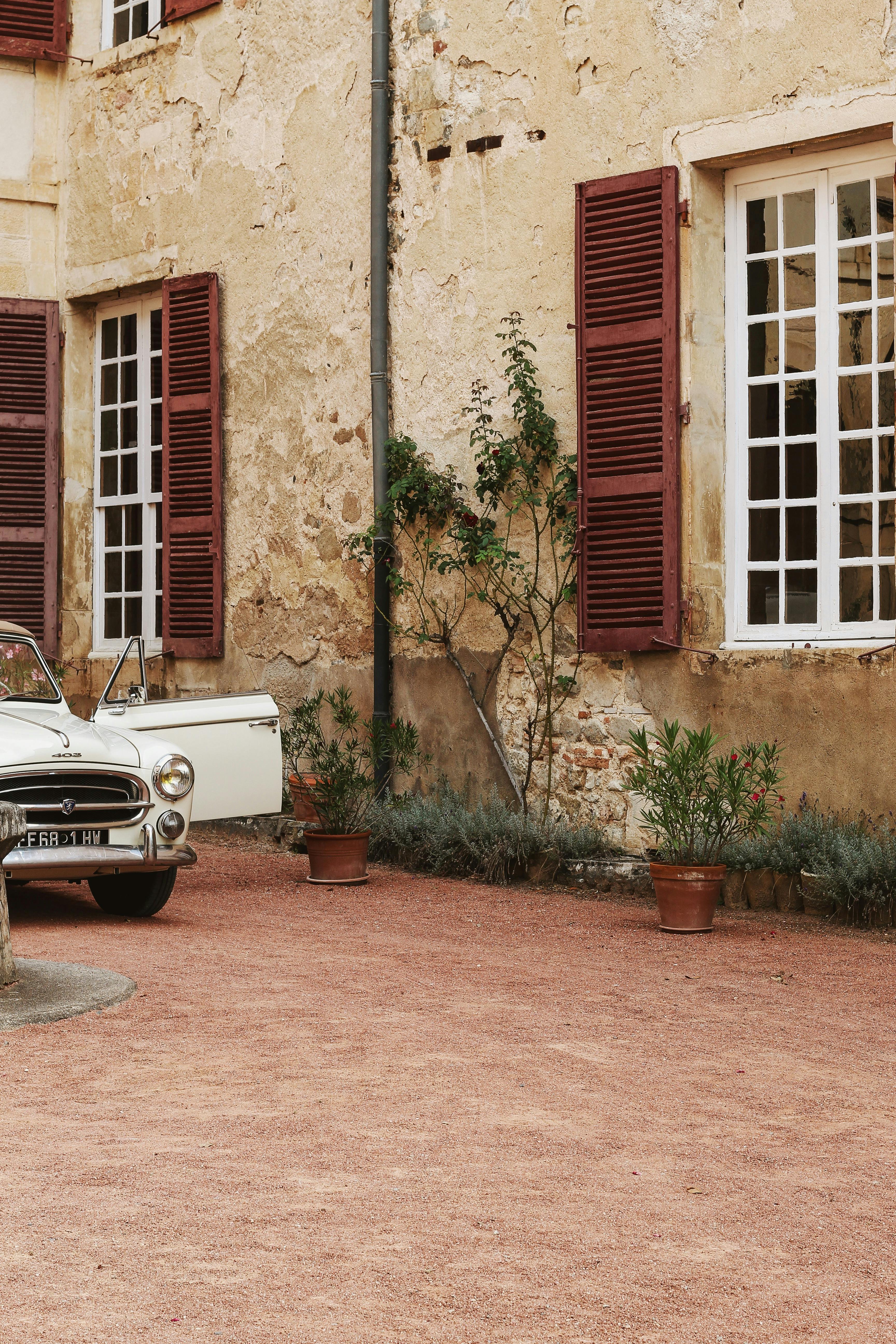 Charming French Courtyard with Vintage Car · Free Stock Photo