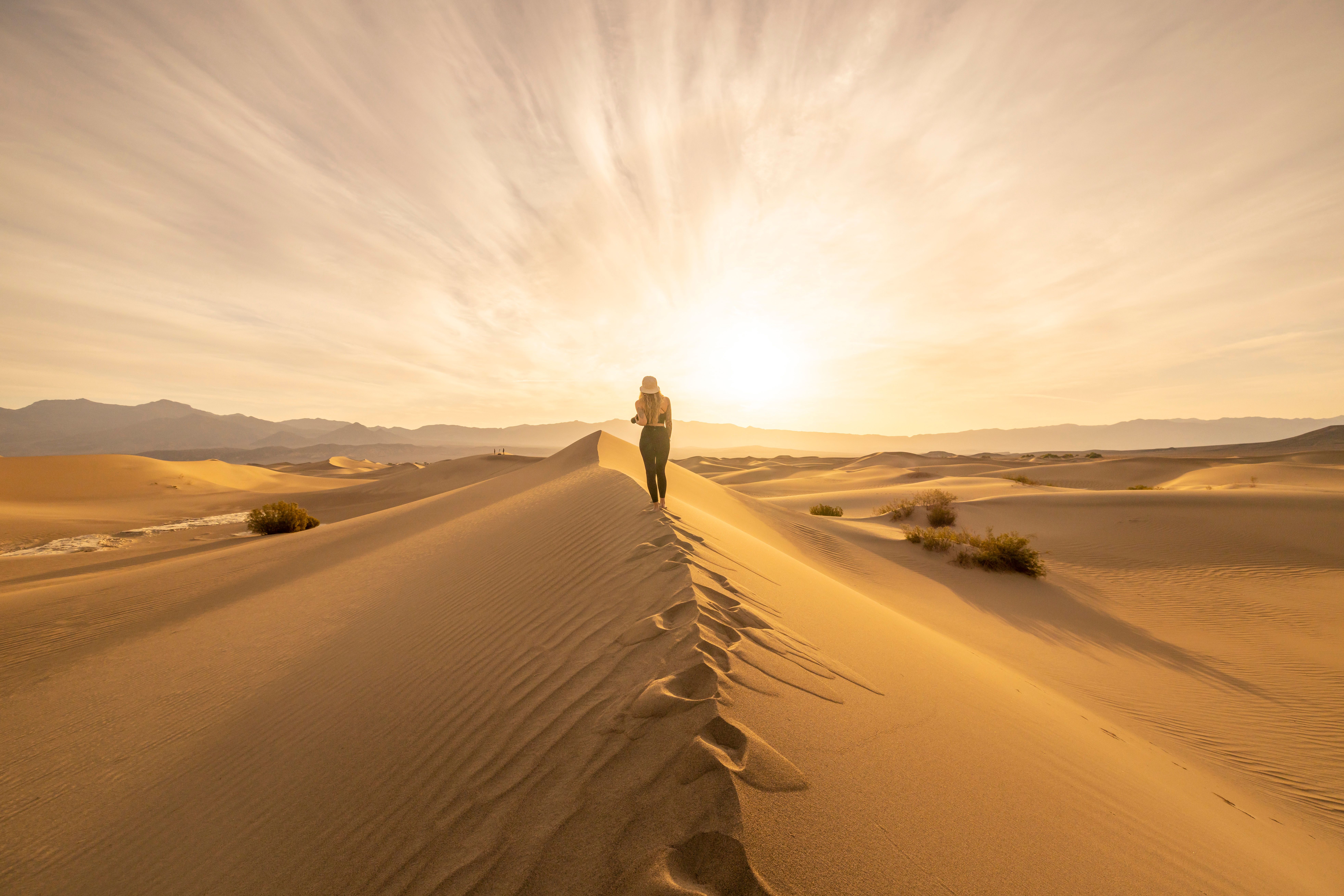 Woman Walking on Desert Sand Dunes at Sunrise · Free Stock Photo