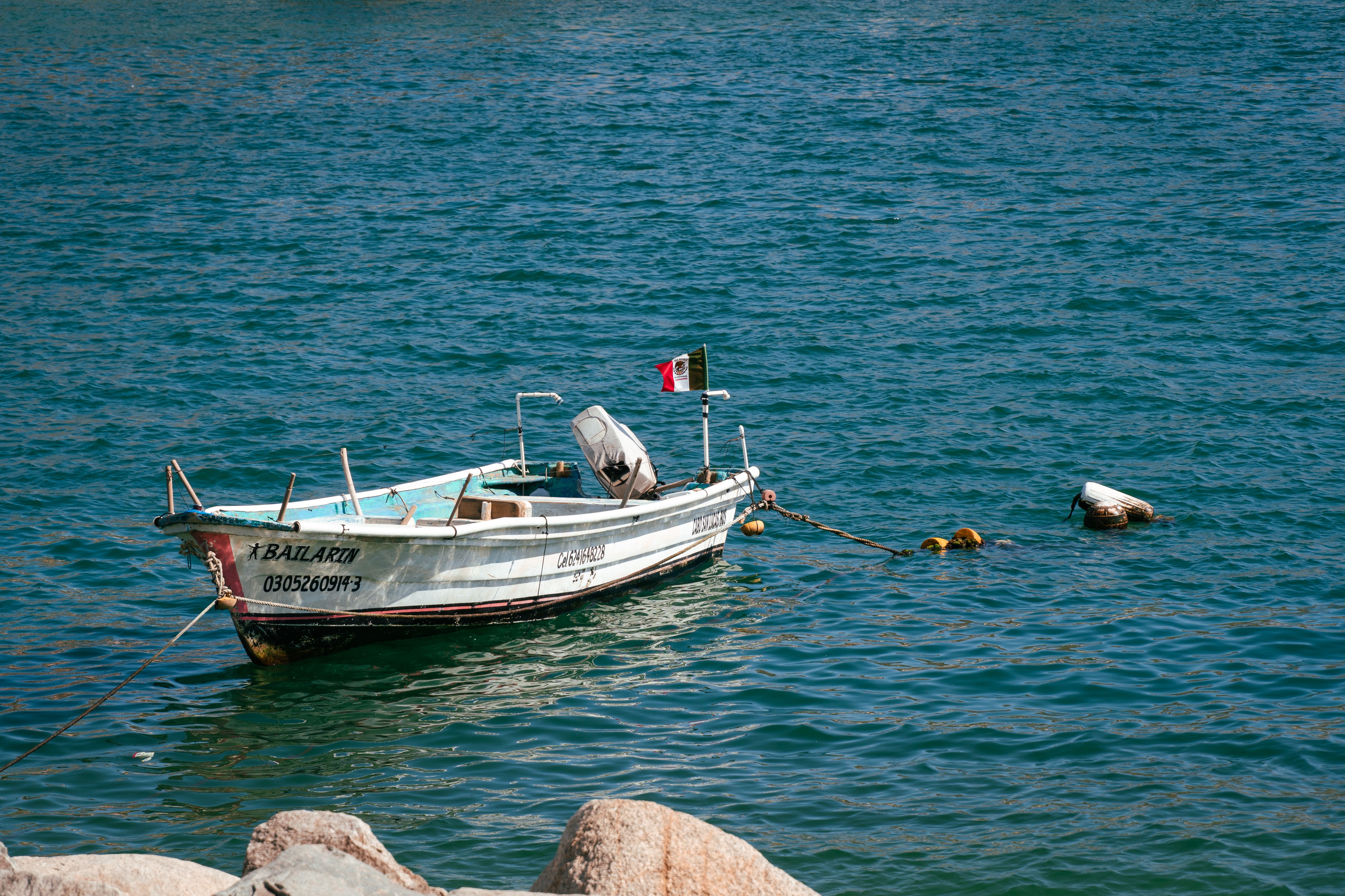 Small Fishing Boat Floating on Calm Blue Sea · Free Stock Photo