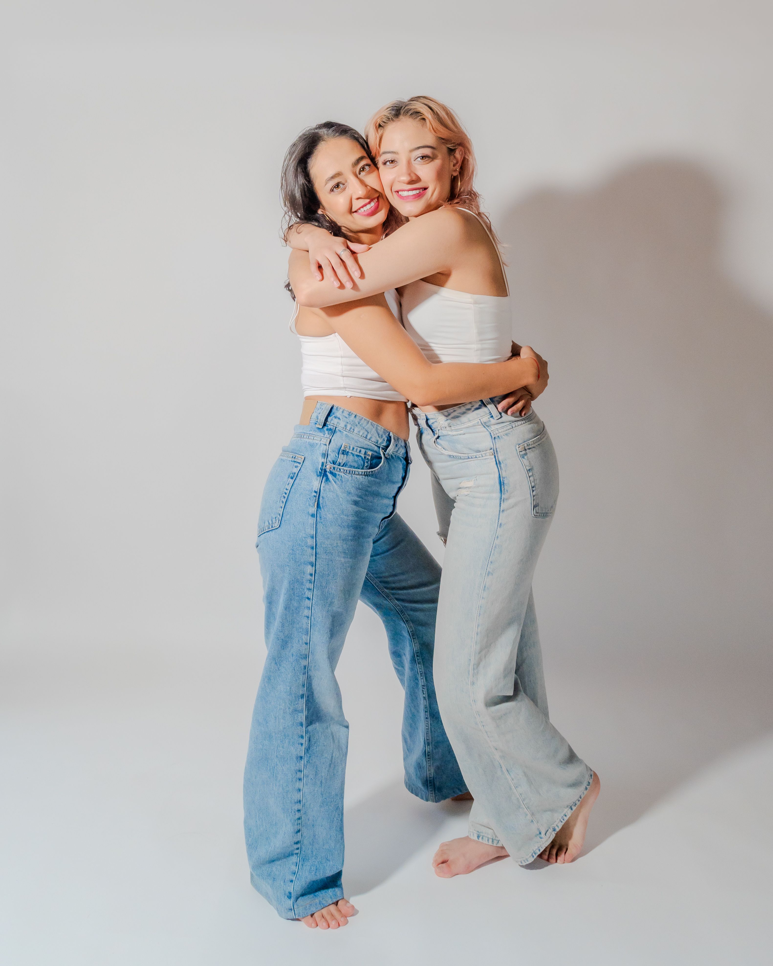 Joyful Friends Embracing in Studio Portrait · Free Stock Photo