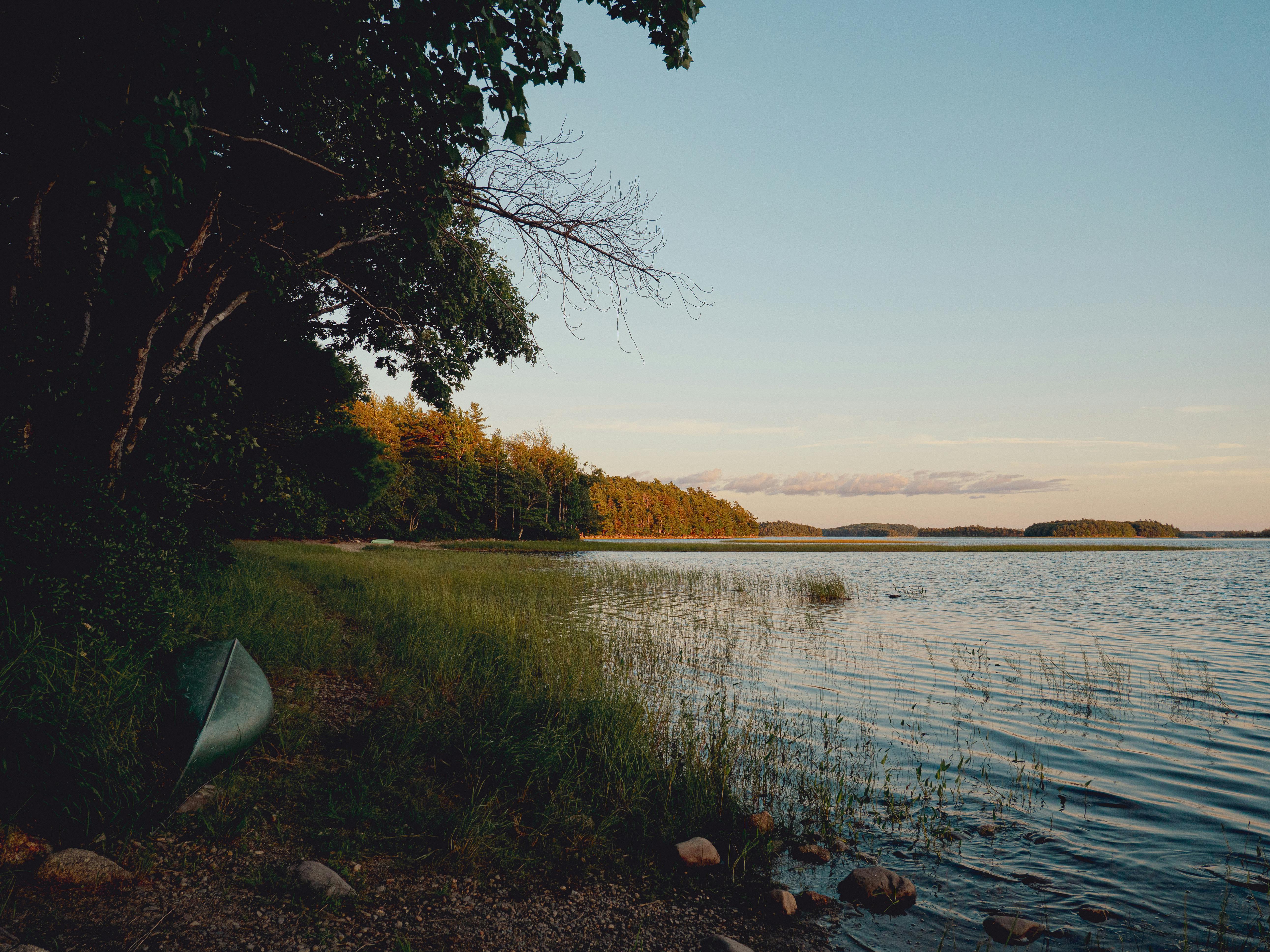 Tranquil Lakeside View at Sunset with Canoe · Free Stock Photo