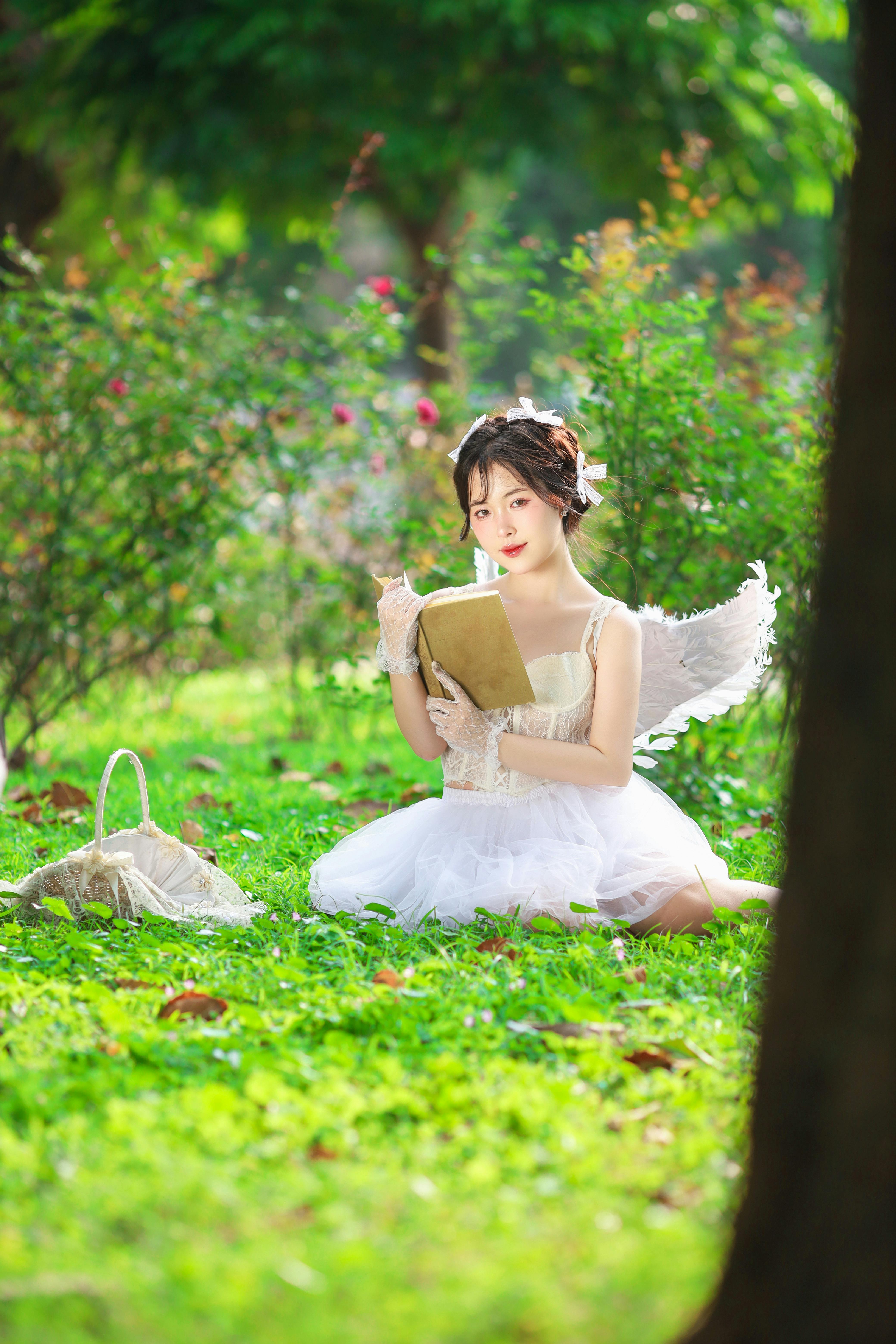 Enchanting Angel Reading in a Garden Setting · Free Stock Photo