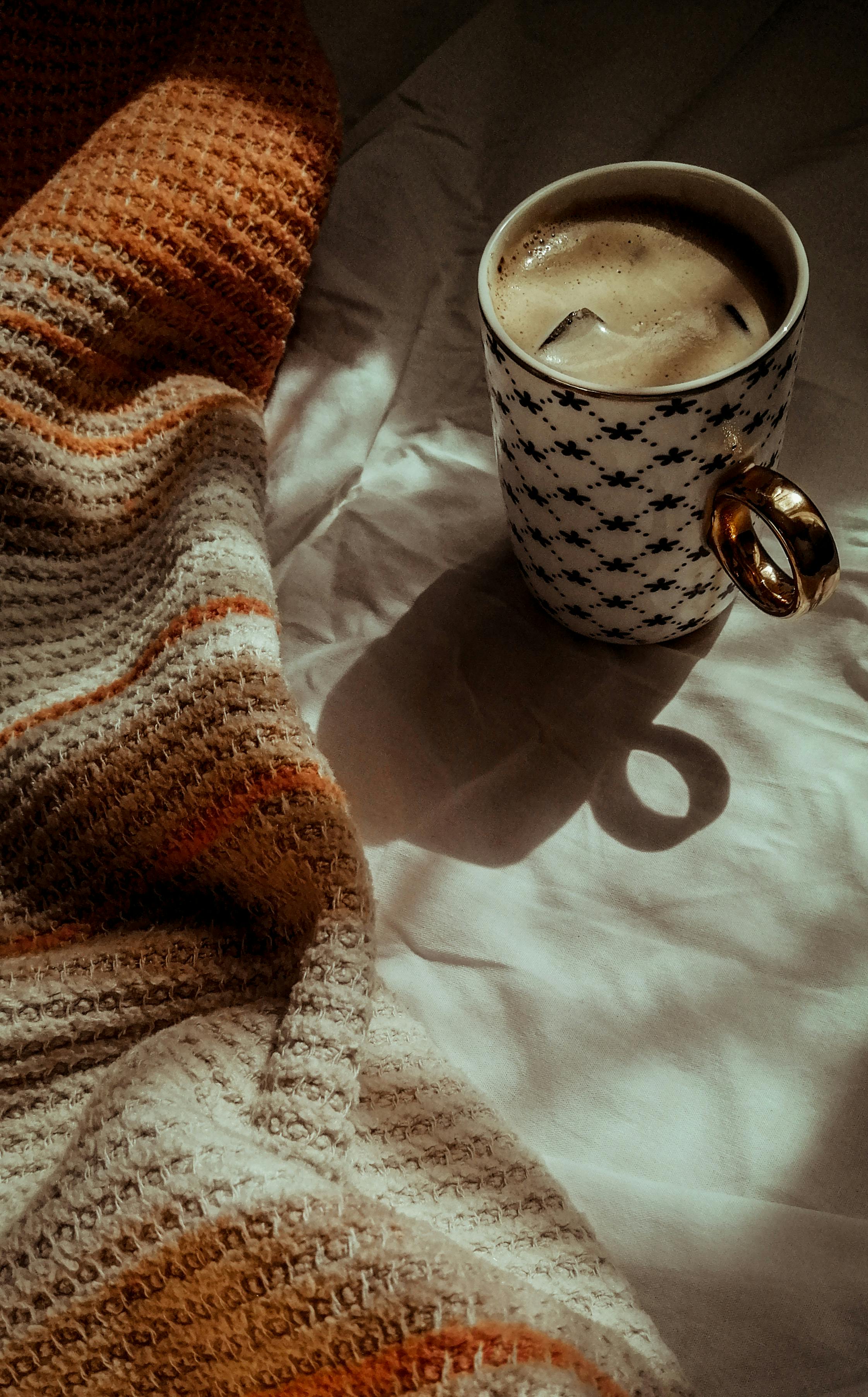 Cozy morning scene with coffee and blanket · Free Stock Photo