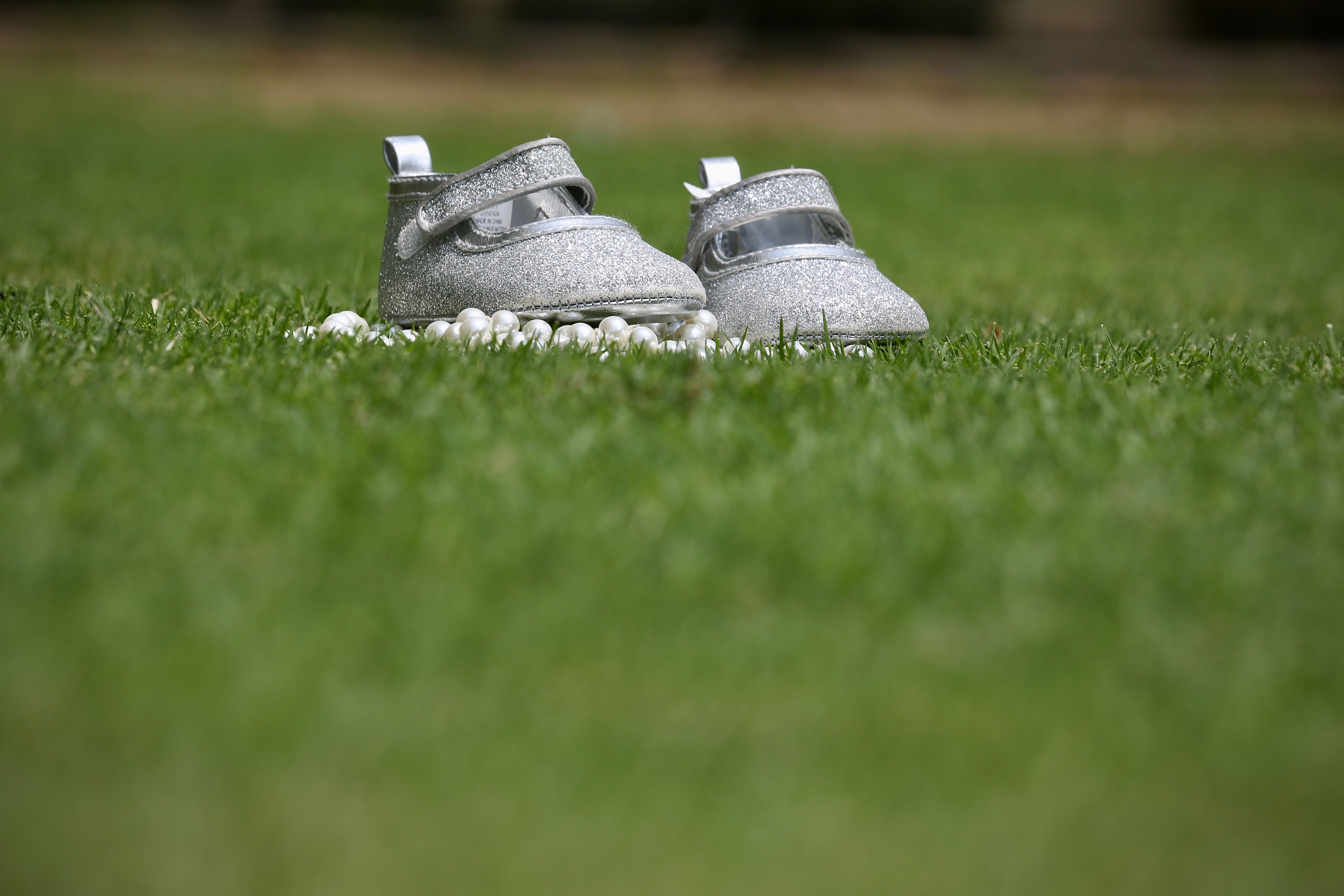 Adorable Silver Baby Shoes on Green Grass · Free Stock Photo