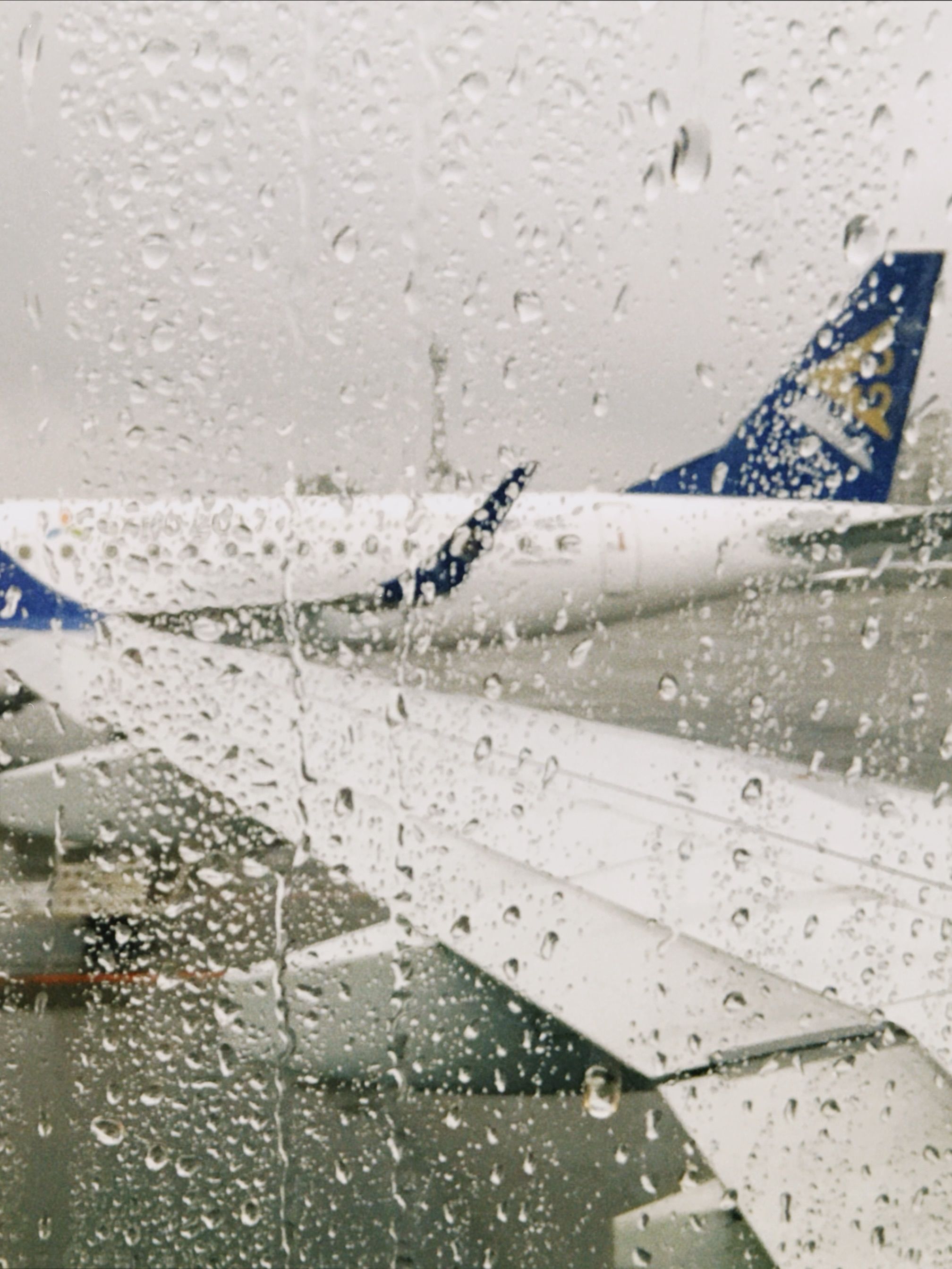 Rainy Airport Window View of Airplane Wing · Free Stock Photo