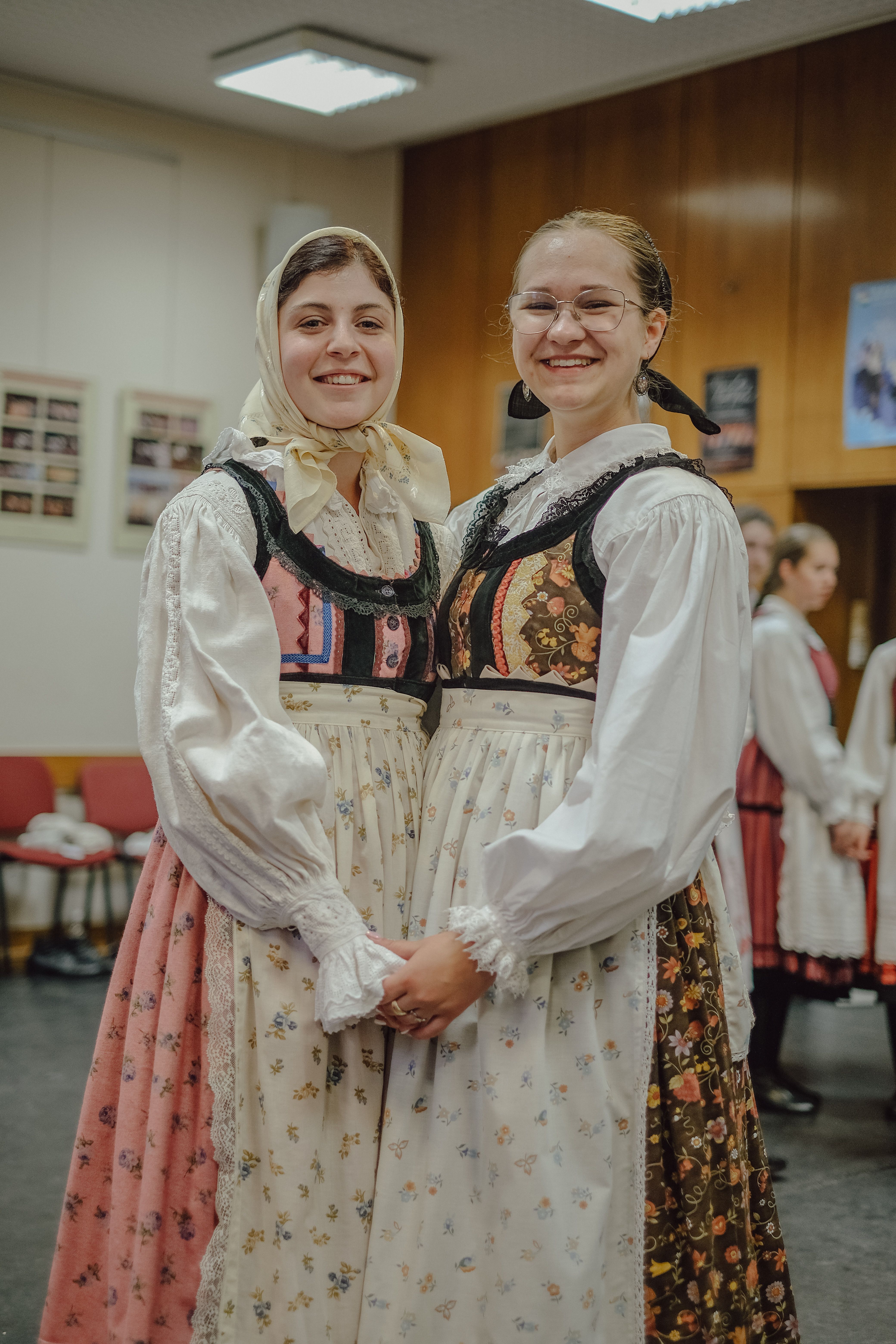 Traditional Folk Costumes of Two Smiling Women Indoors · Free Stock Photo