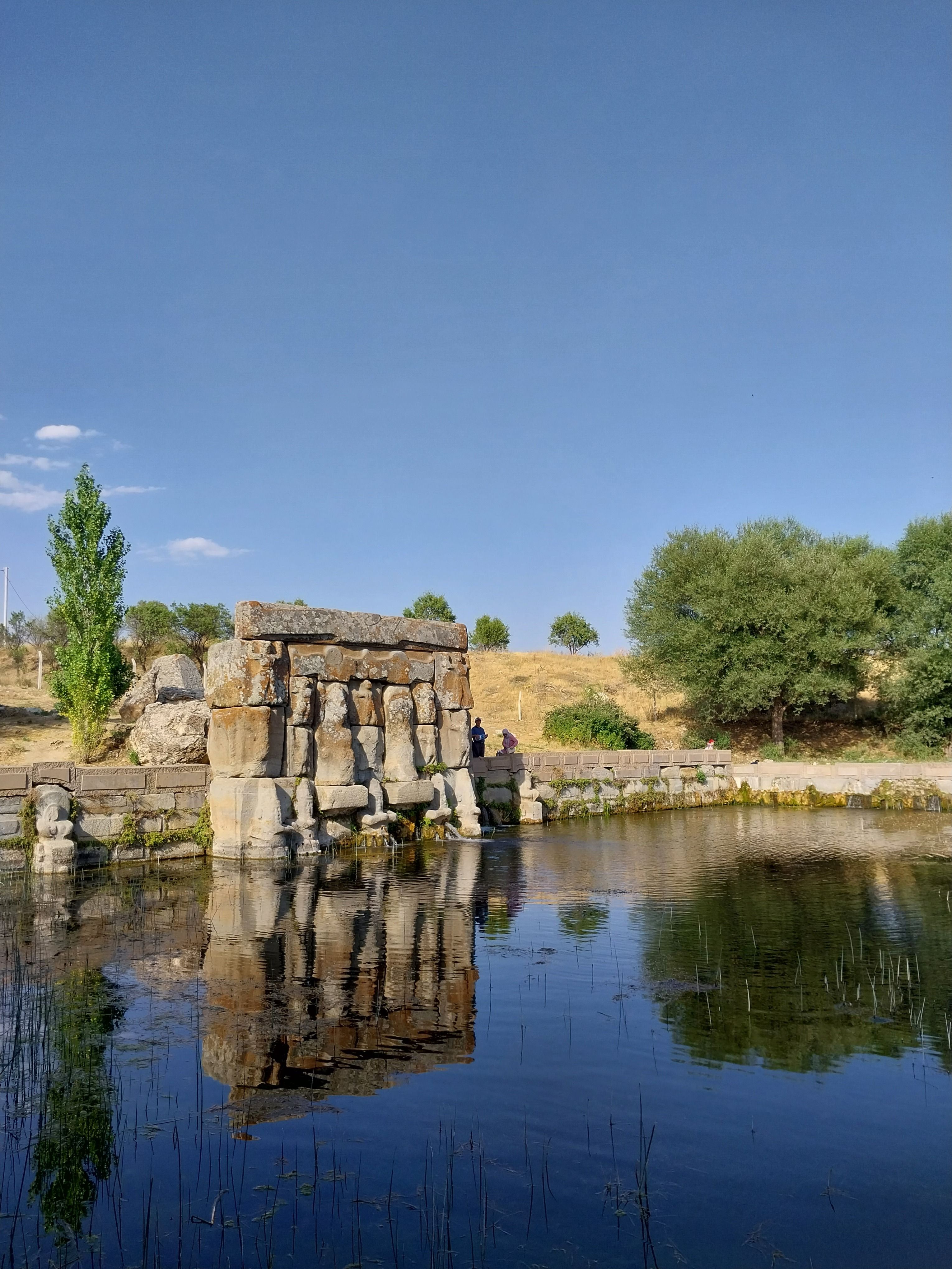 Ancient Stone Sculpture by Reflective Pond · Free Stock Photo