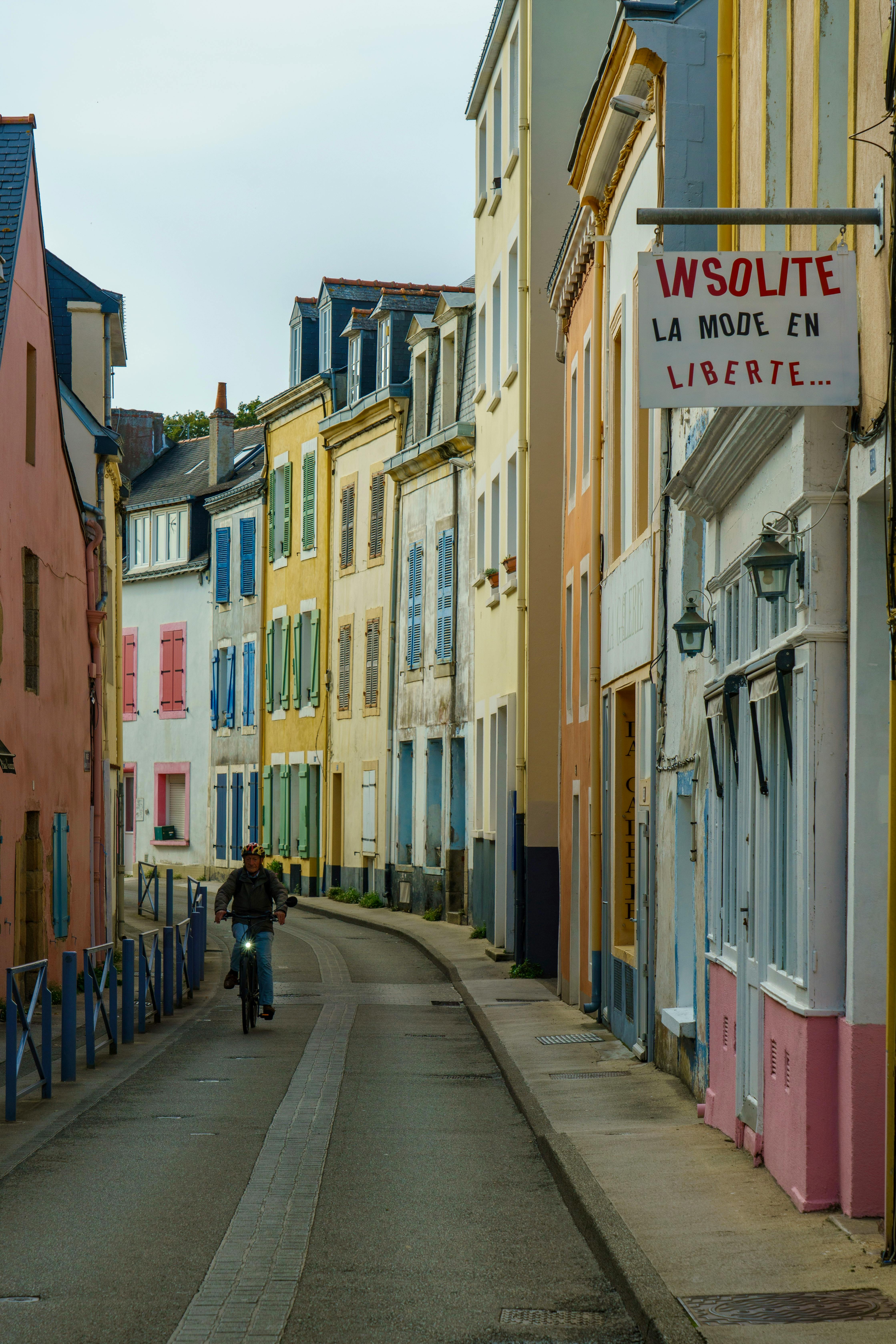 Cyclist in Colorful French Street in Le Palais · Free Stock Photo