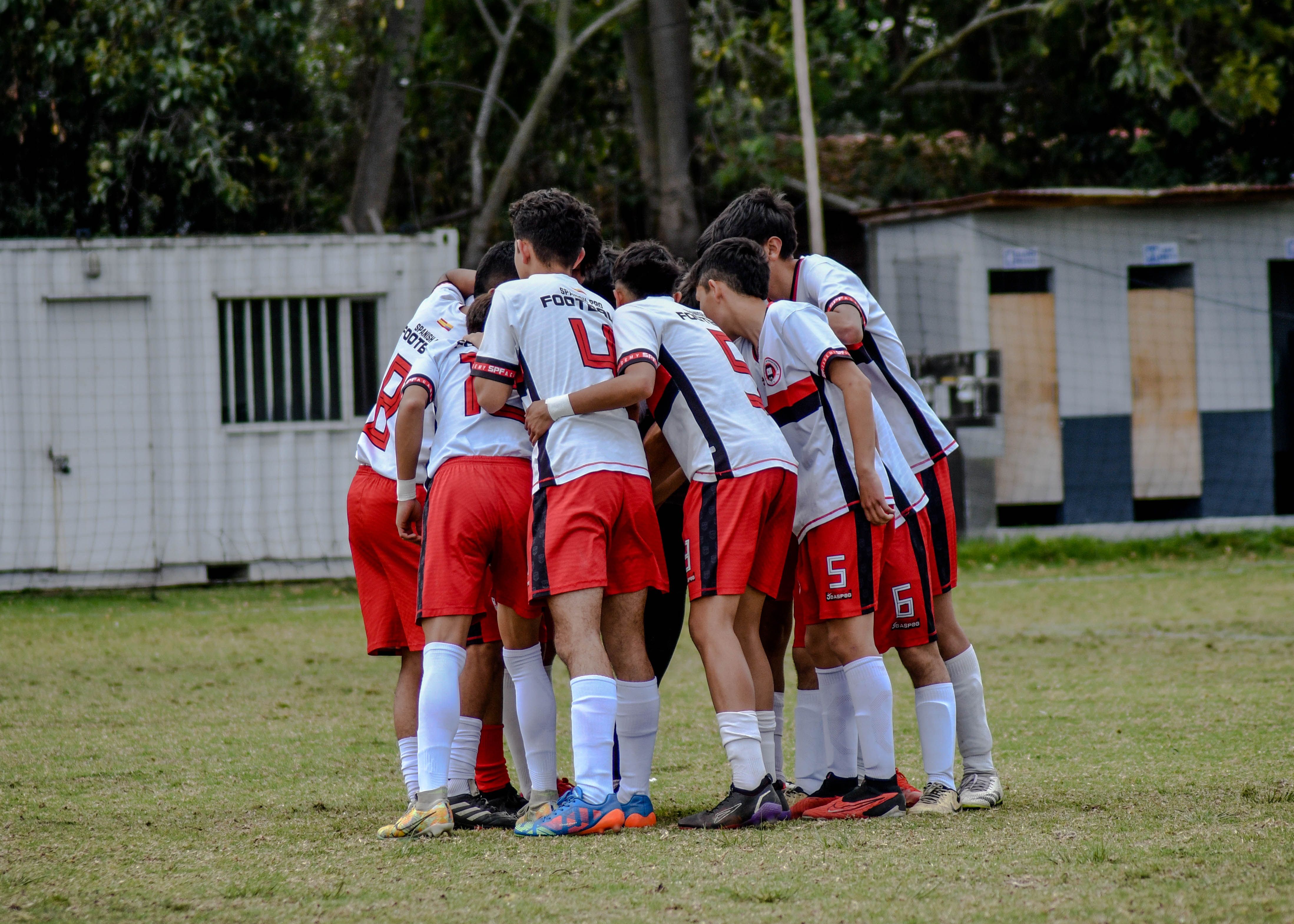 Youth Soccer Team Huddle on Field · Free Stock Photo