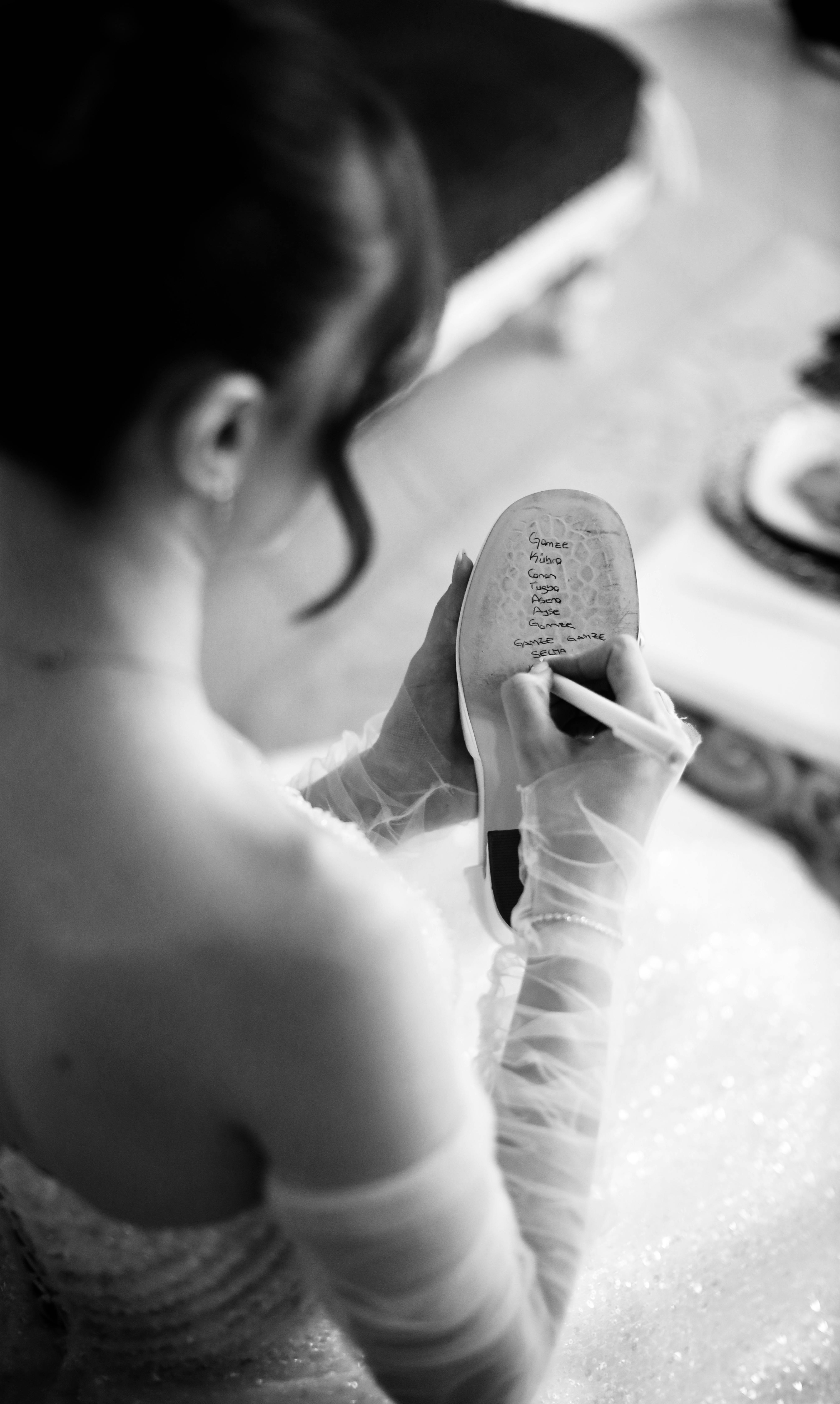 Bride Writing on Shoe Sole in Black and White · Free Stock Photo