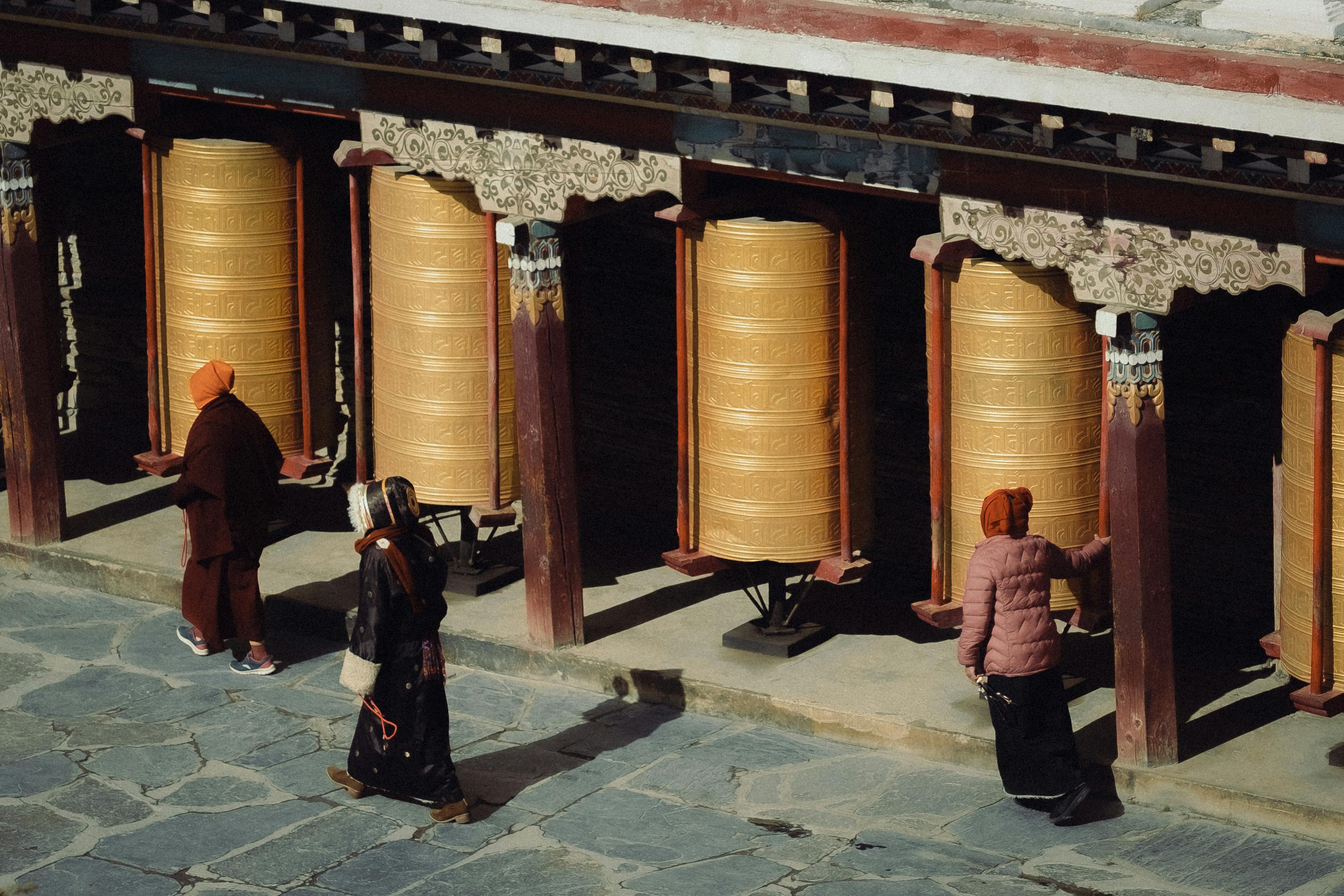 Pilgrims Spinning Prayer Wheels in a Temple · Free Stock Photo