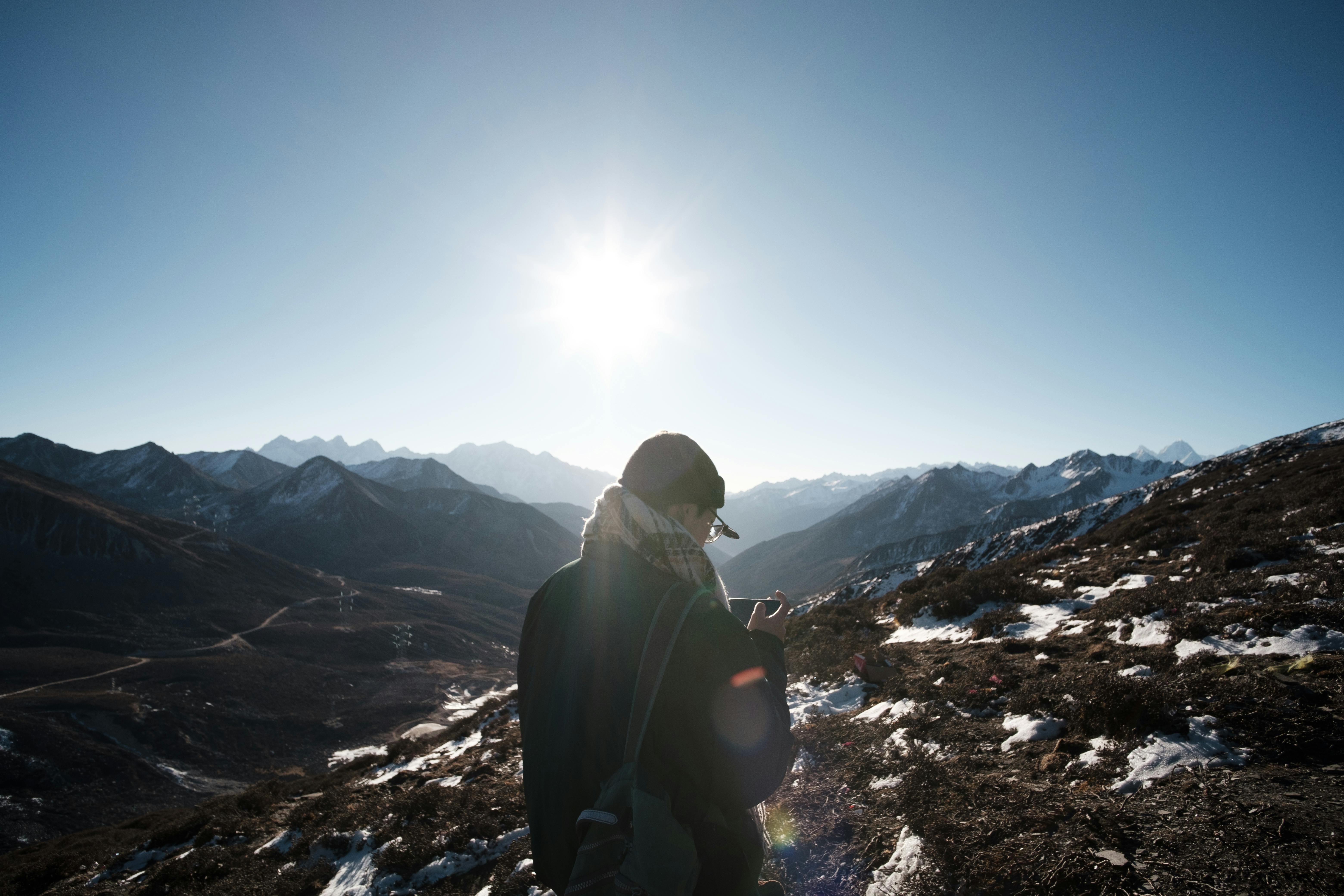 Exploring Snowy Mountain Terrain in Winter Sunlight · Free Stock Photo
