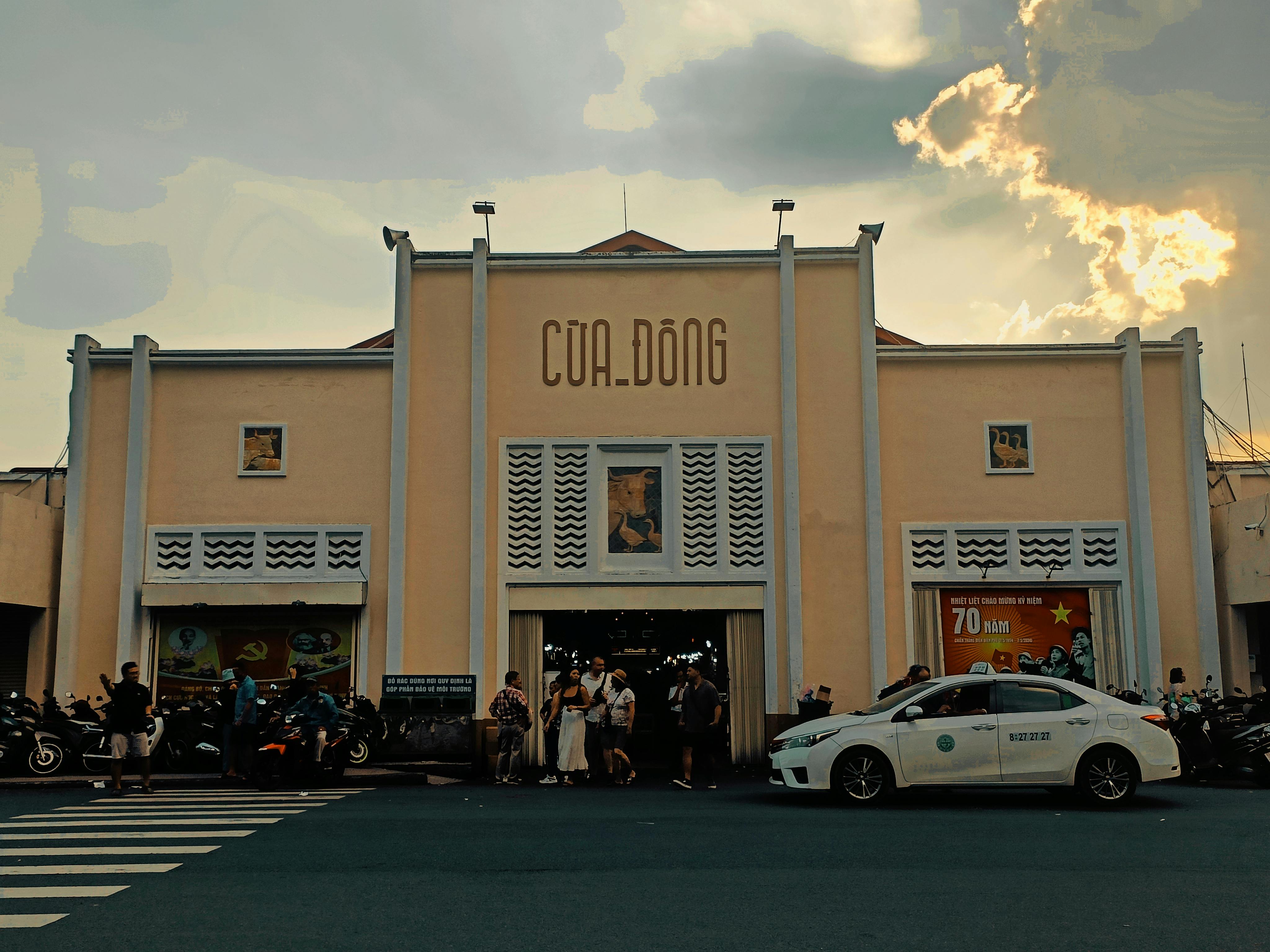 Historic Market Entrance with Gathering Crowd at Dusk · Free Stock Photo