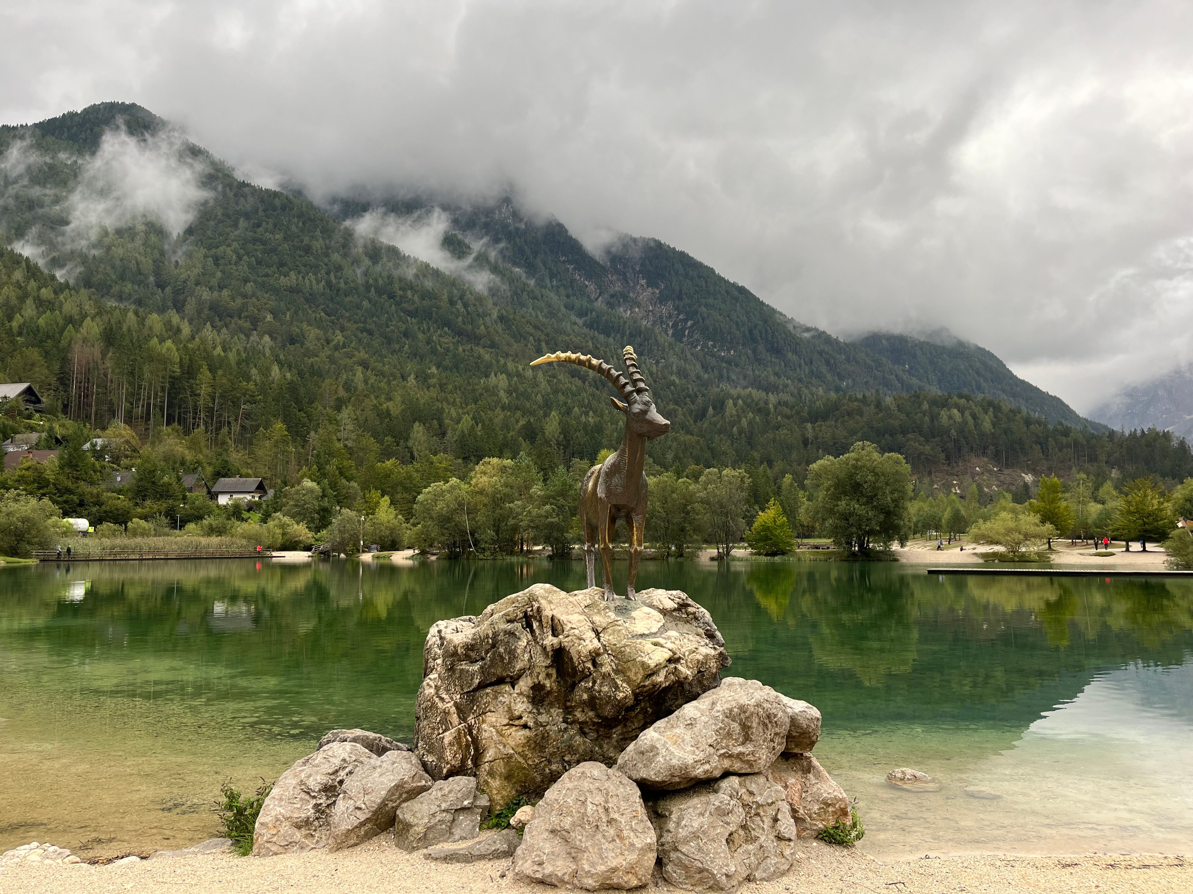 Tranquil Lake Scene with Ibex Sculpture · Free Stock Photo