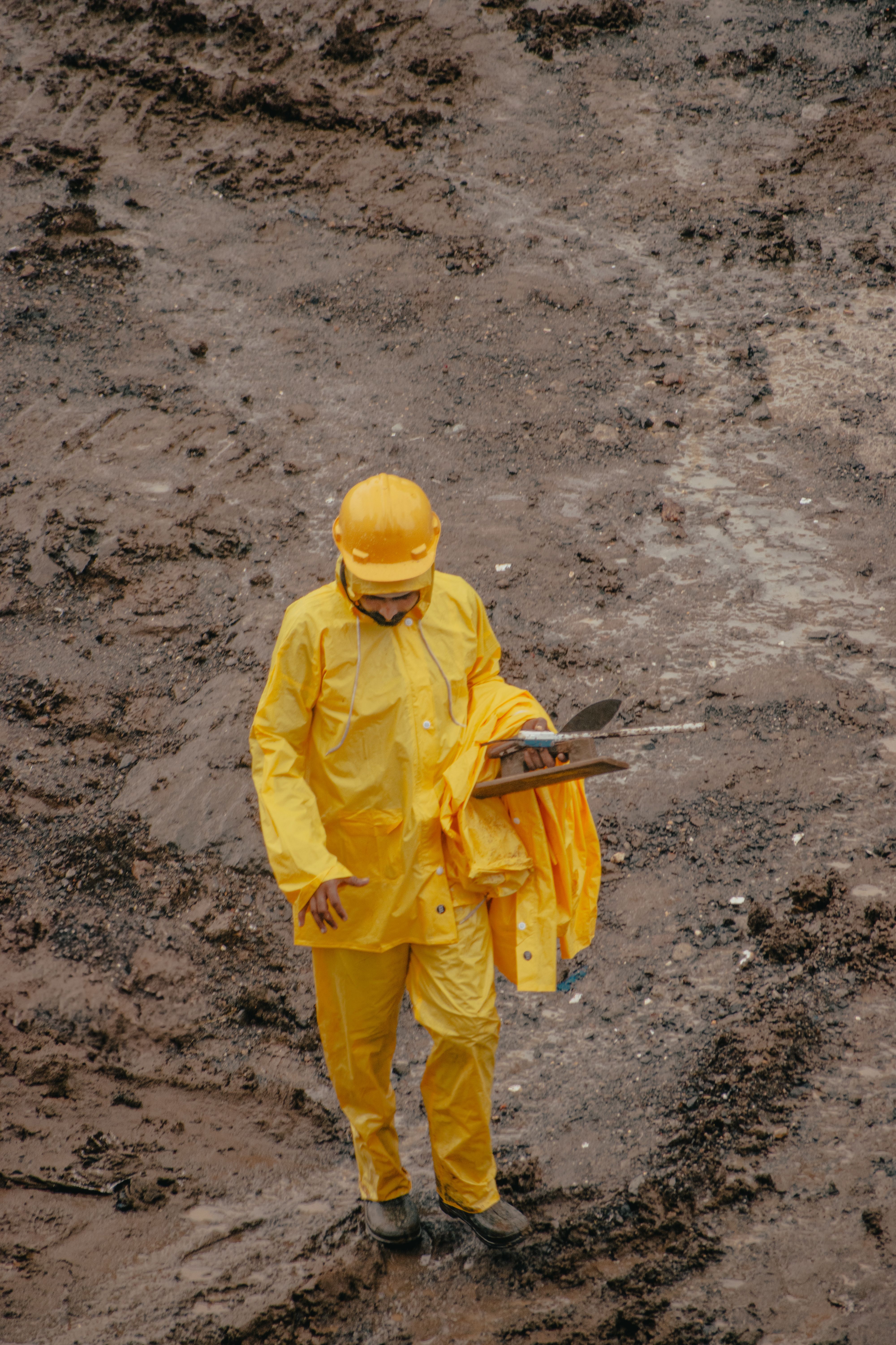 Trabajador De La Construcción Con Ropa Impermeable Amarilla En Un Sitio ...