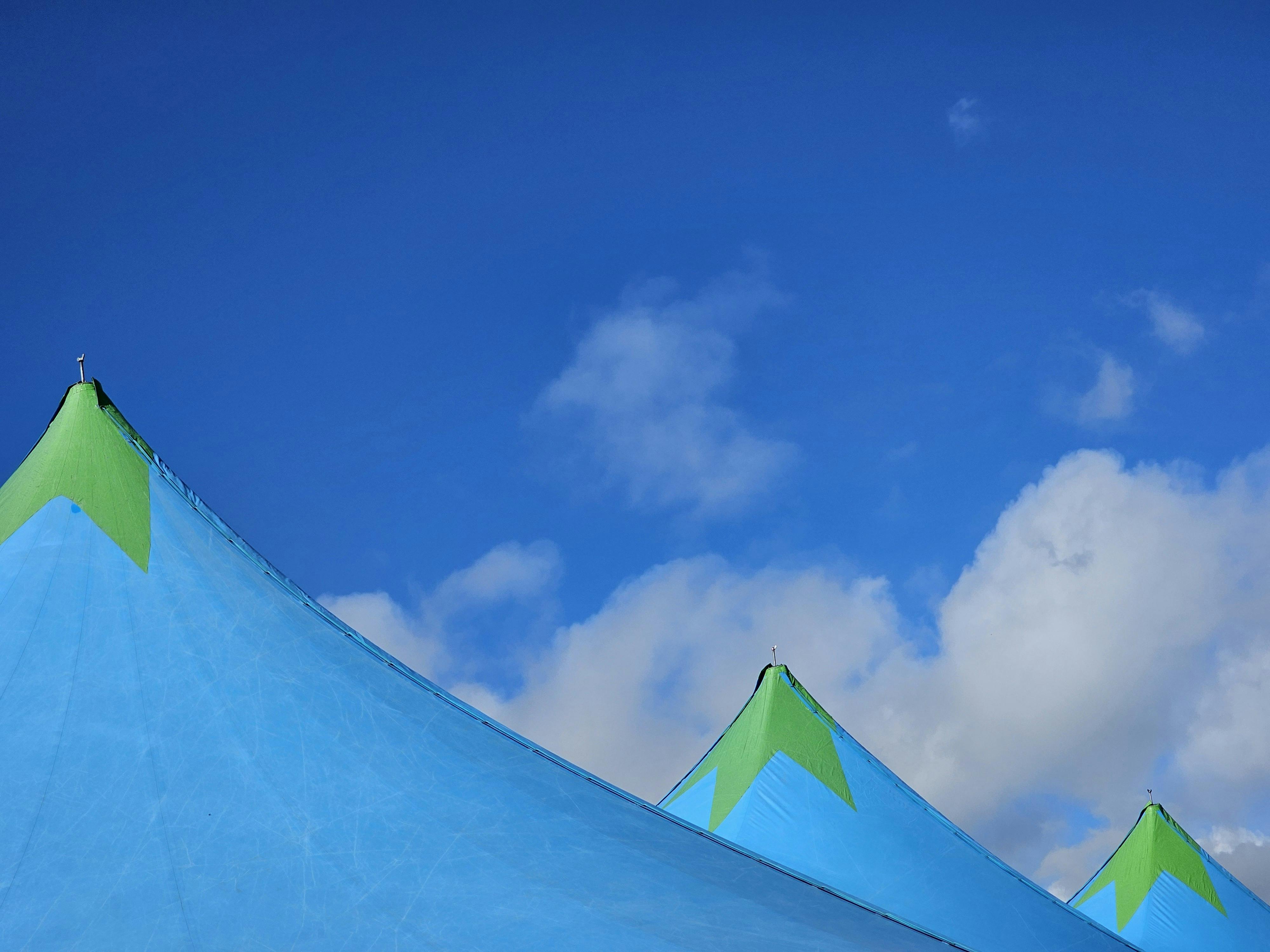 Blue Tent Peaks Against Bright Blue Sky · Free Stock Photo