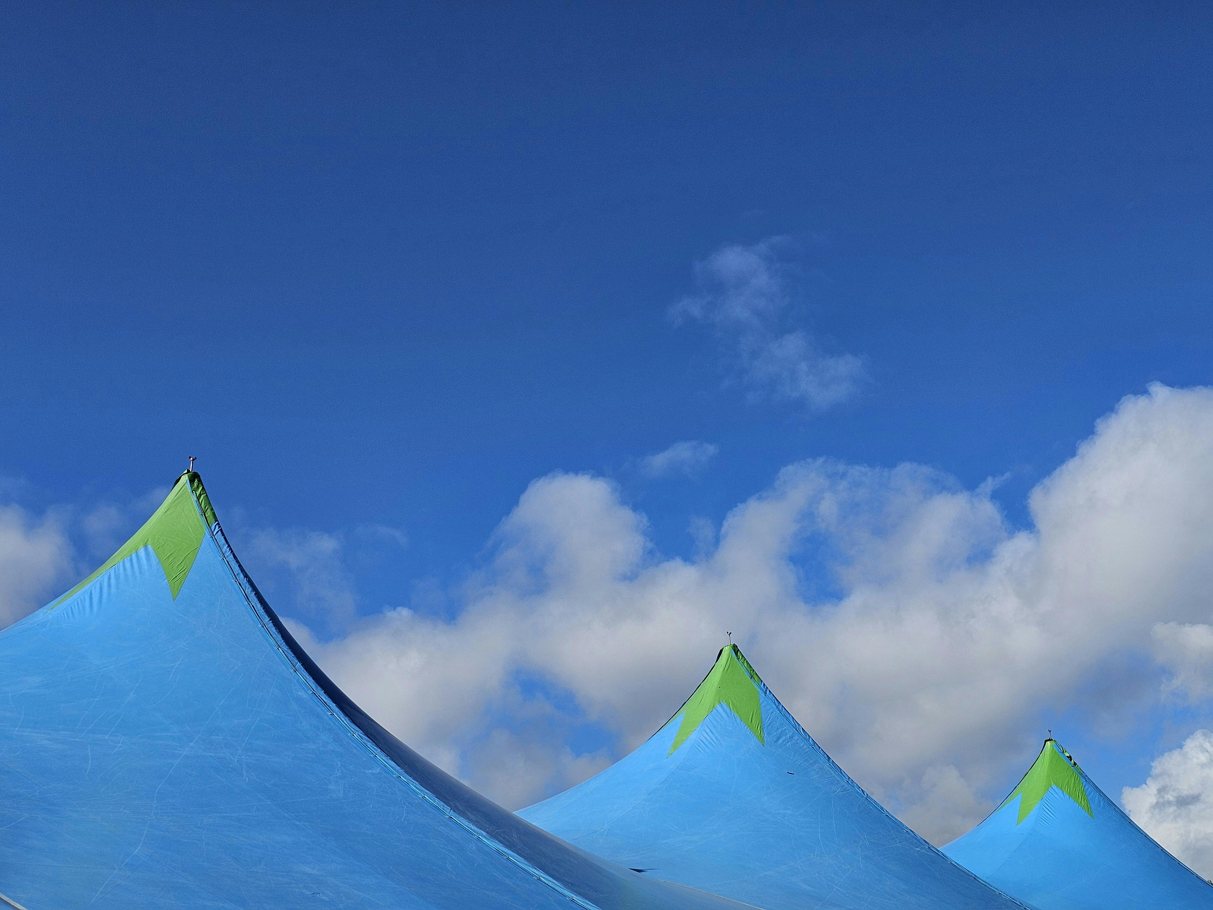 Bright Blue Tents Under a Clear Sky · Free Stock Photo