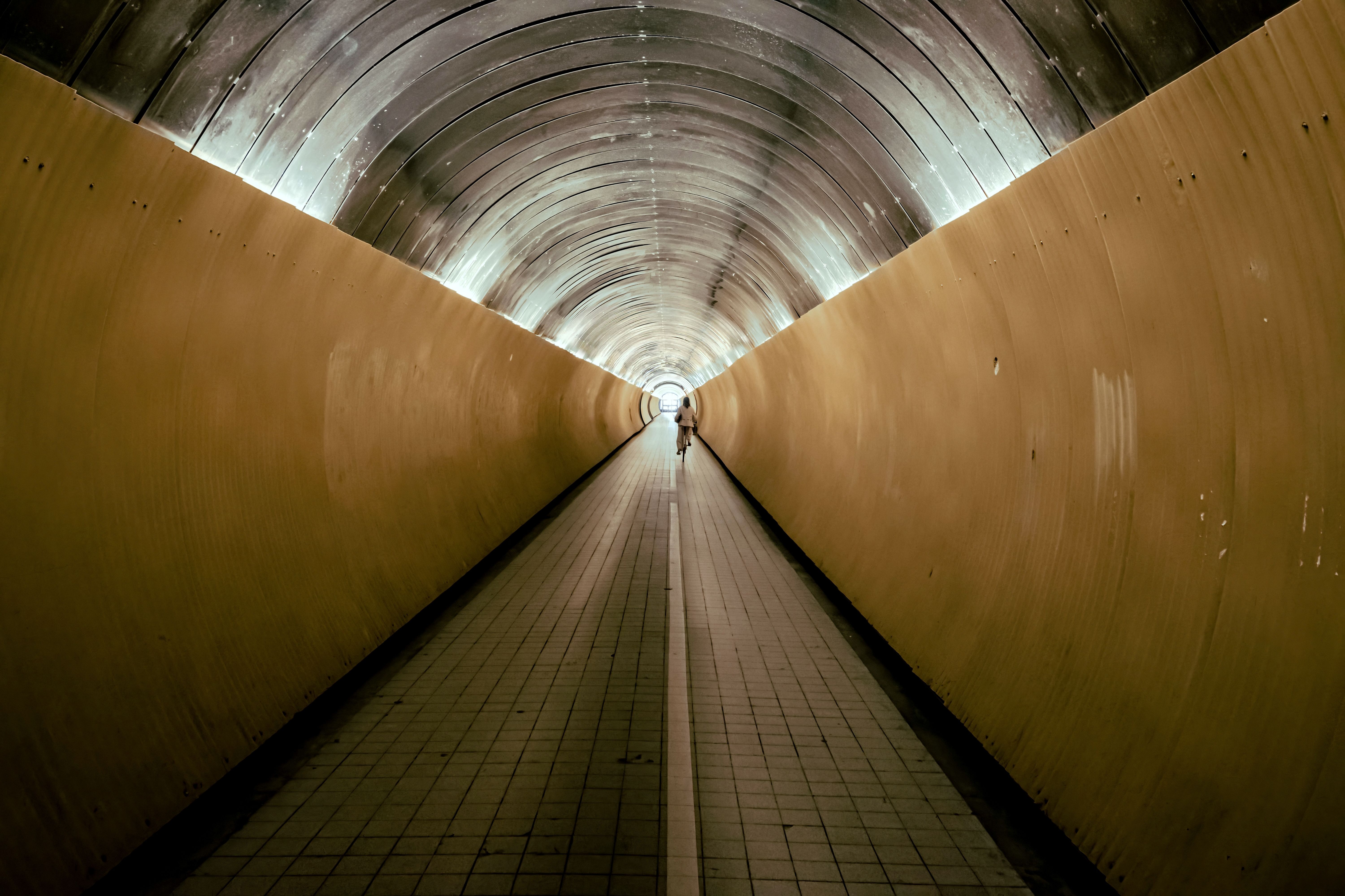 Person Walking Through Modern Urban Tunnel · Free Stock Photo