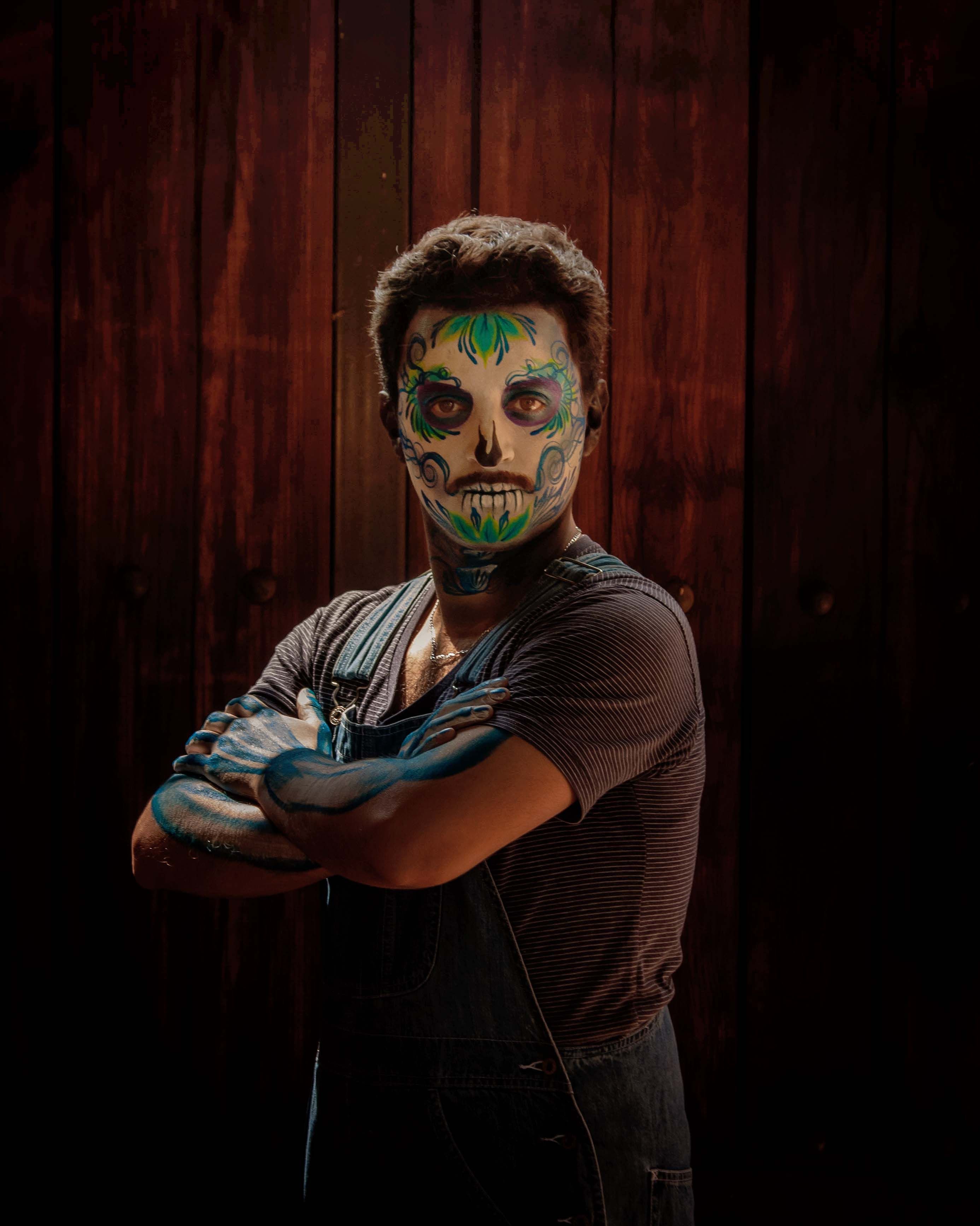 Man with Intricate Face Paint in Dramatic Lighting · Free Stock Photo