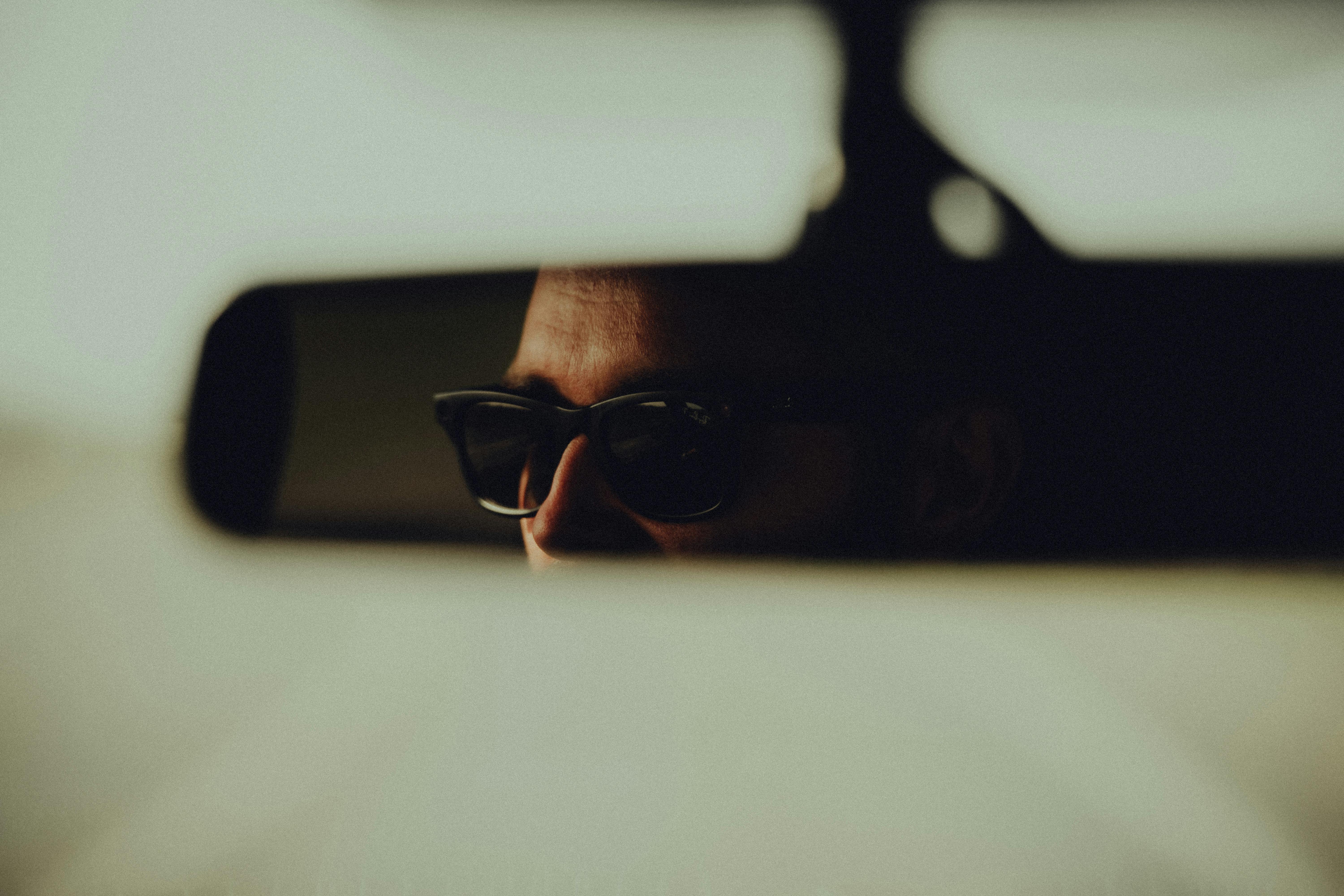 Rearview Mirror Reflection of Man Wearing Sunglasses · Free Stock Photo