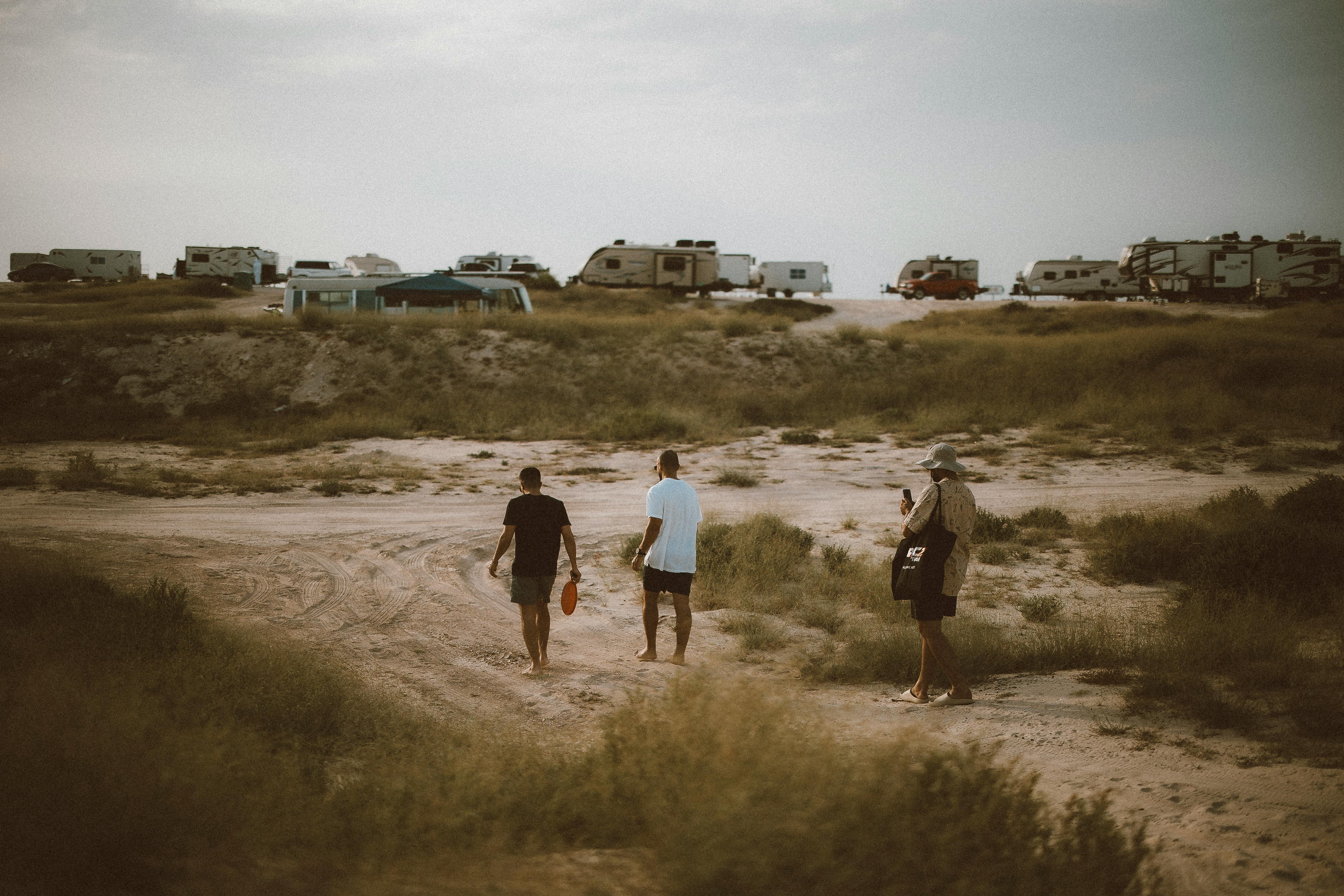 Group Walking Among RVs in Dubai Desert Landscape · Free Stock Photo