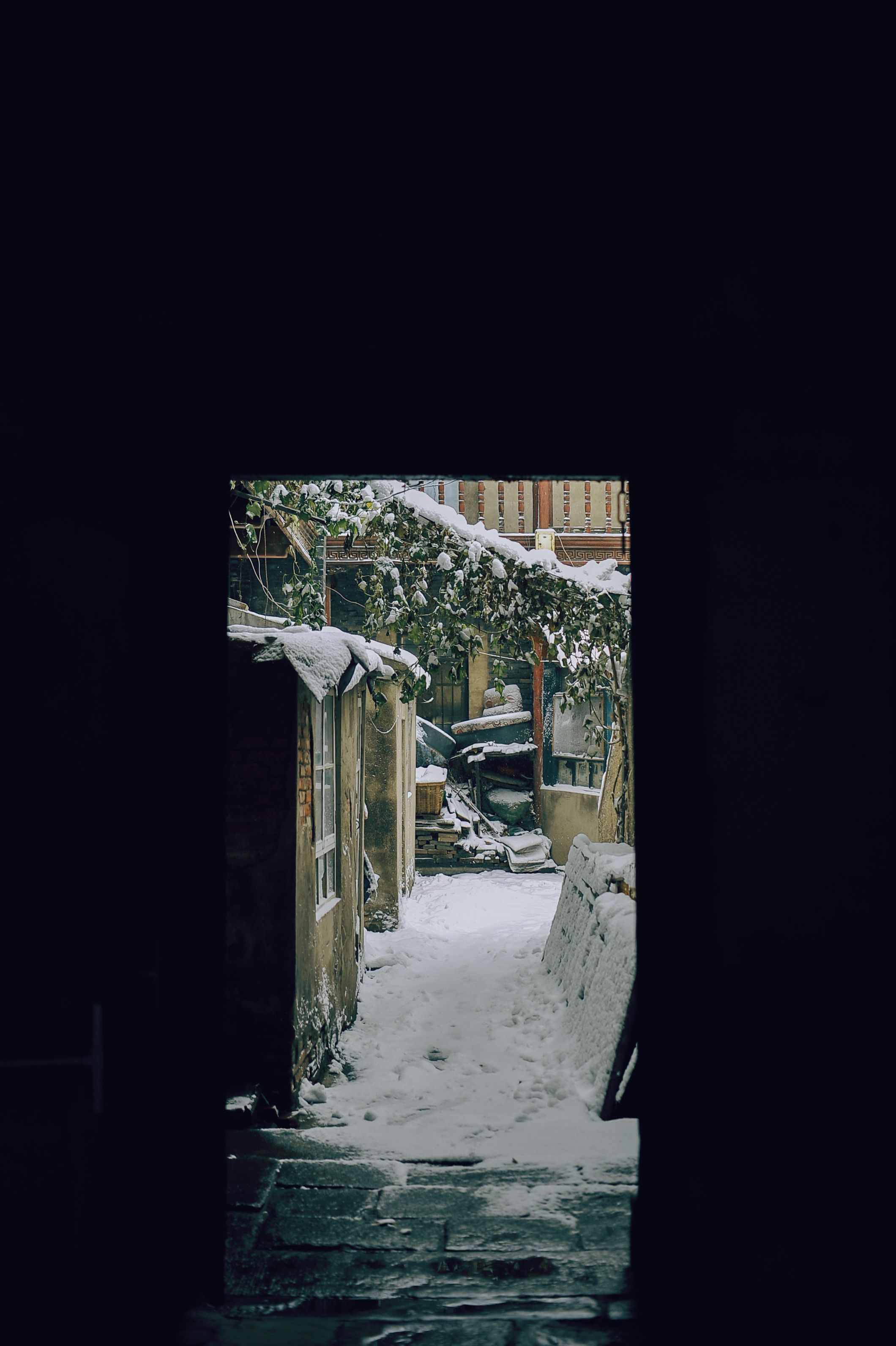 Snowy Alleyway Through a Dark Entrance · Free Stock Photo
