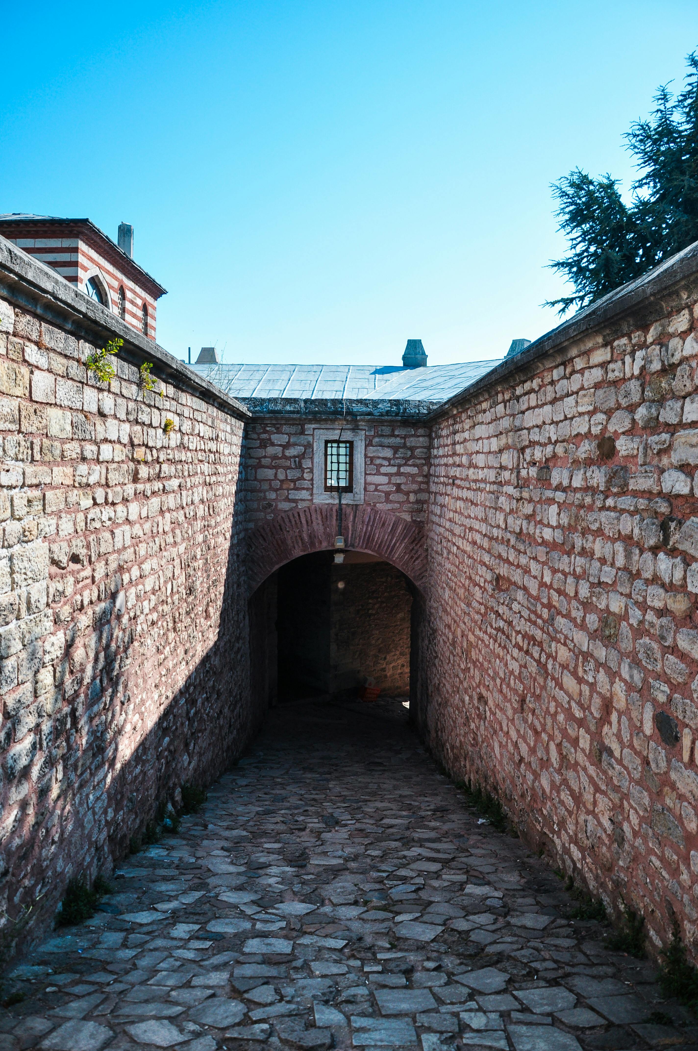 Historic Stone Passageway with Archway and Blue Sky · Free Stock Photo