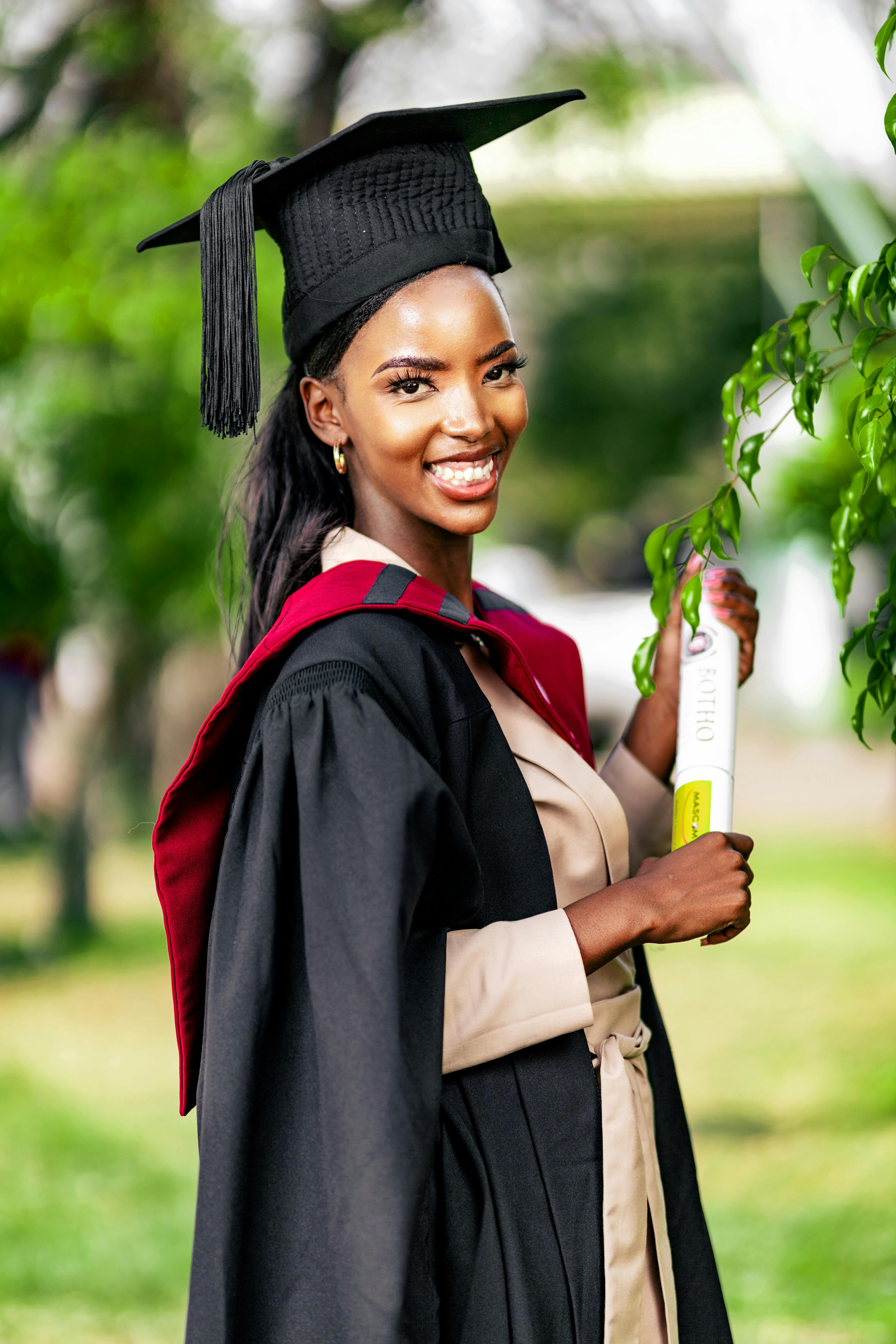 Smiling Graduate Holding Diploma Outdoors · Free Stock Photo