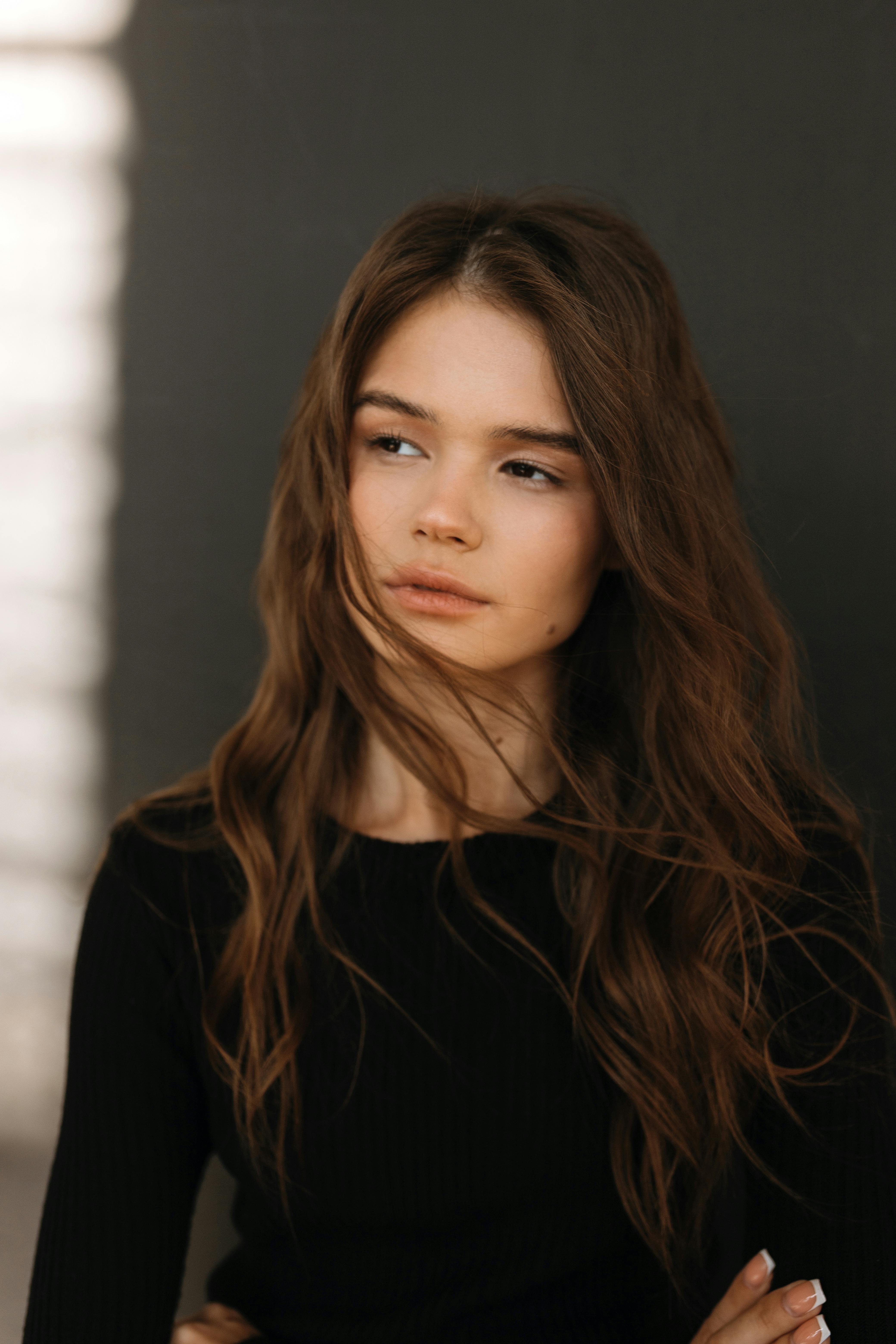 Thoughtful Young Woman Portrait in Soft Light · Free Stock Photo