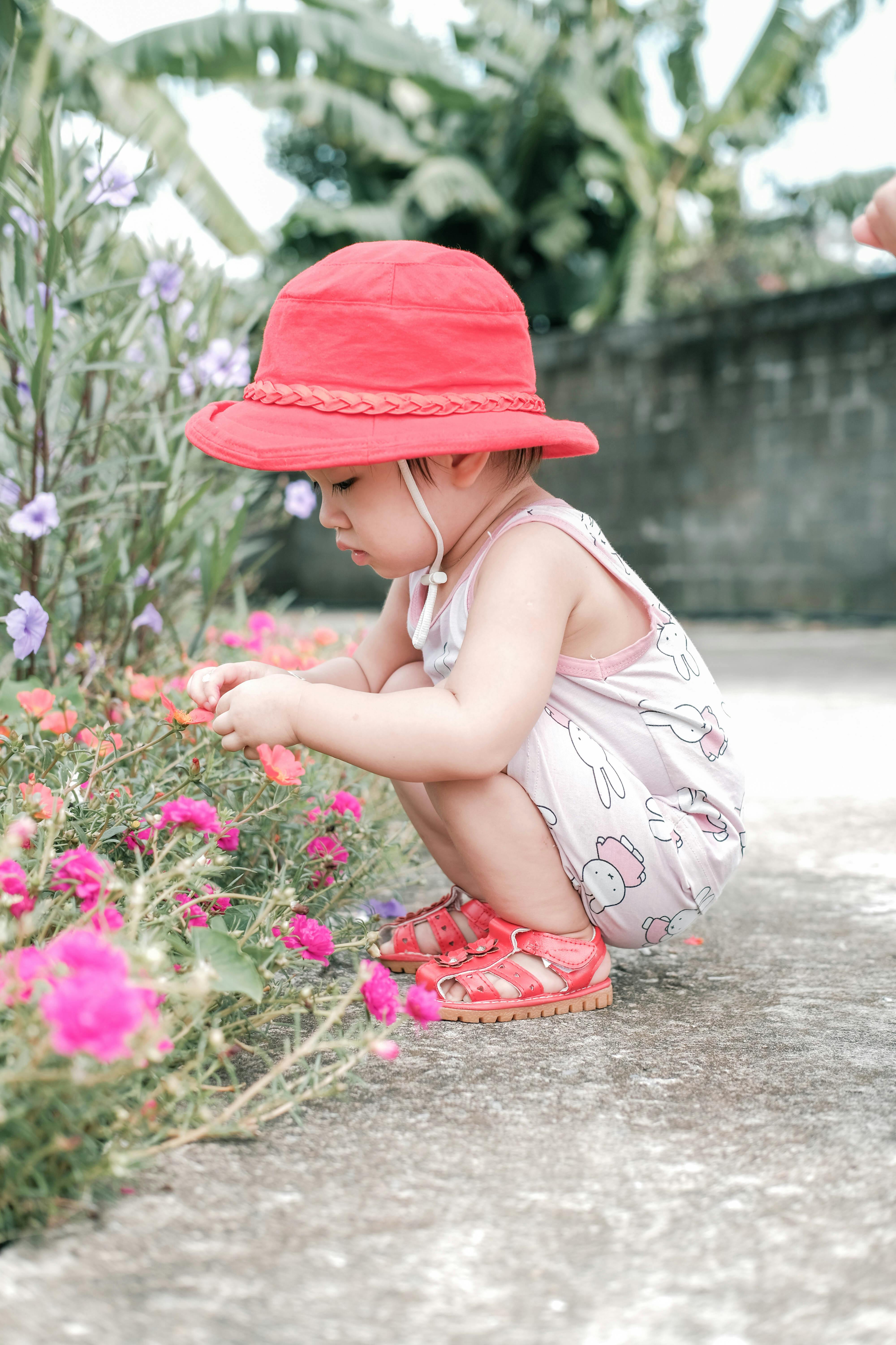 Young Child Enjoying Summer Garden Exploration · Free Stock Photo