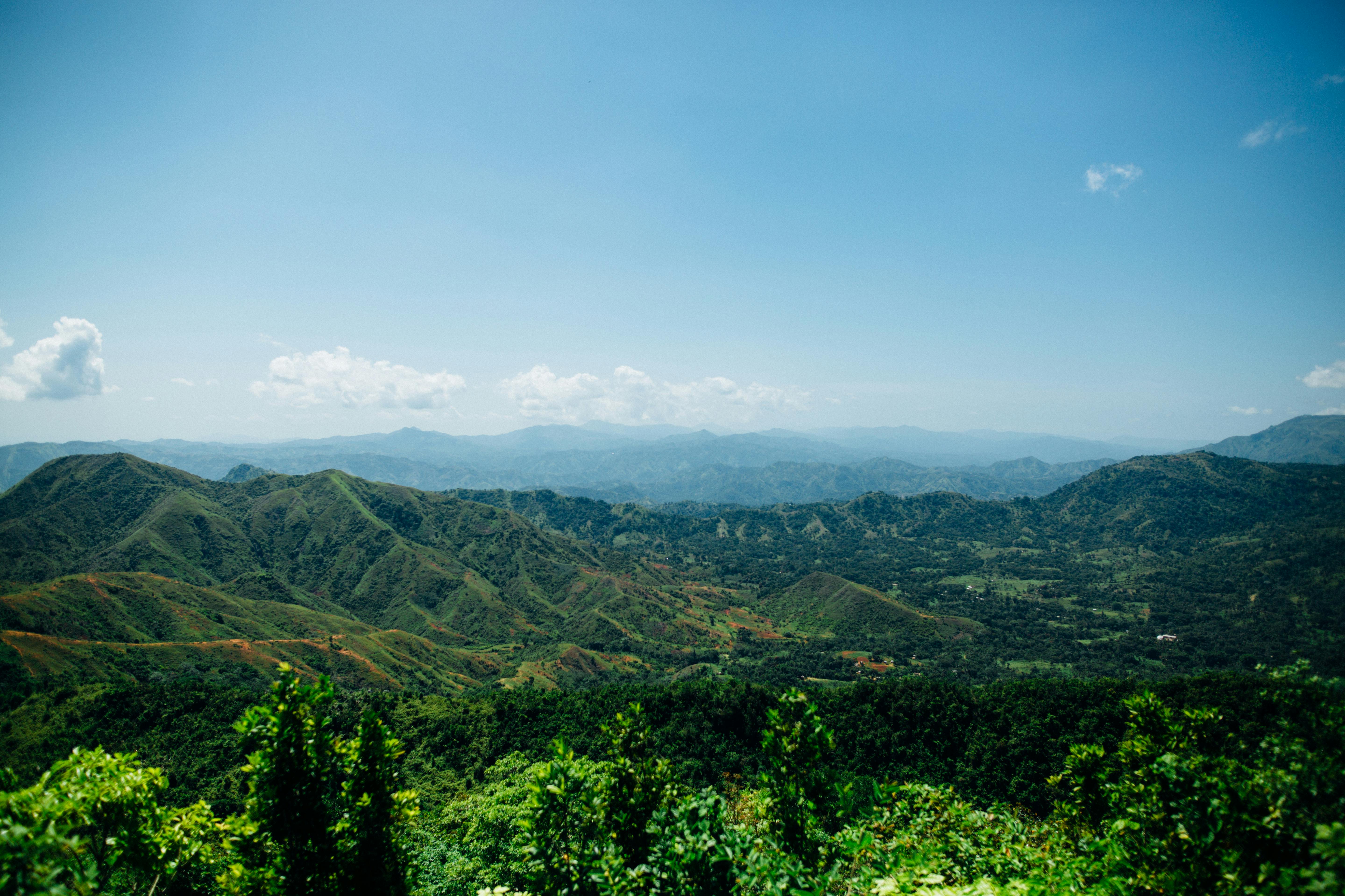 Top View of Hills and Trees Under Blue Sky · Free Stock Photo