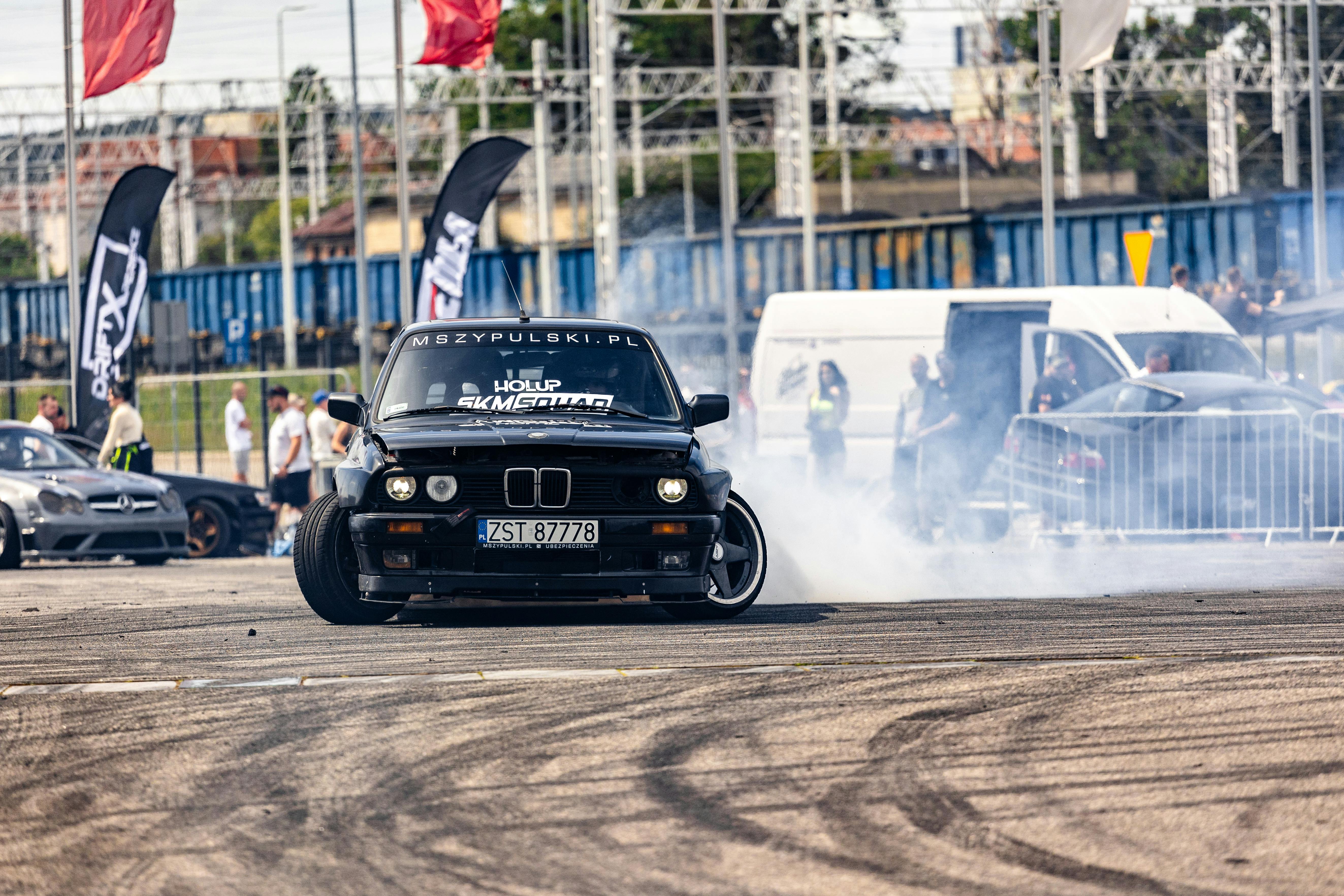 A red and black car is drifting smoke · Free Stock Photo