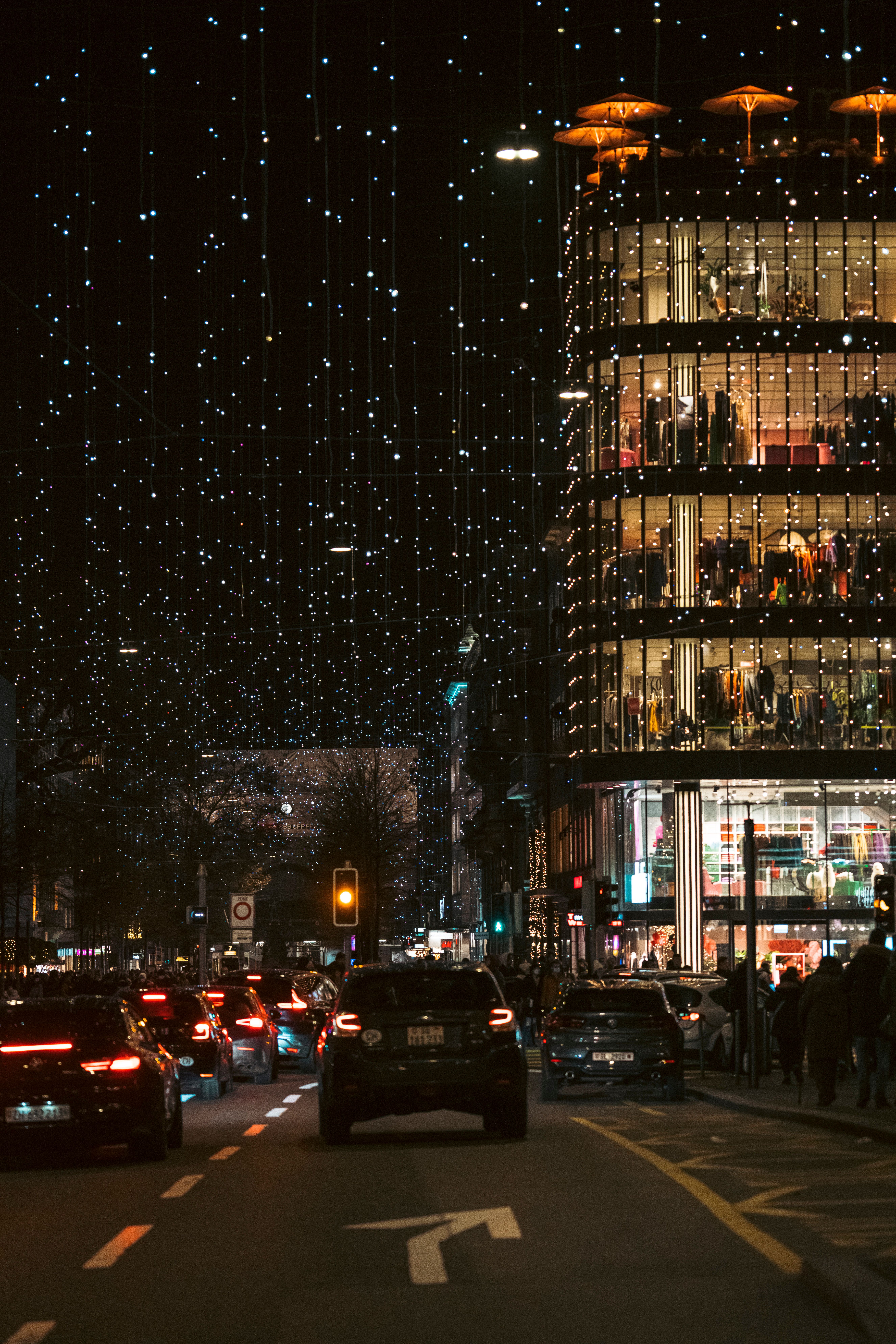 Vibrant Nighttime City Street with Holiday Lights · Free Stock Photo