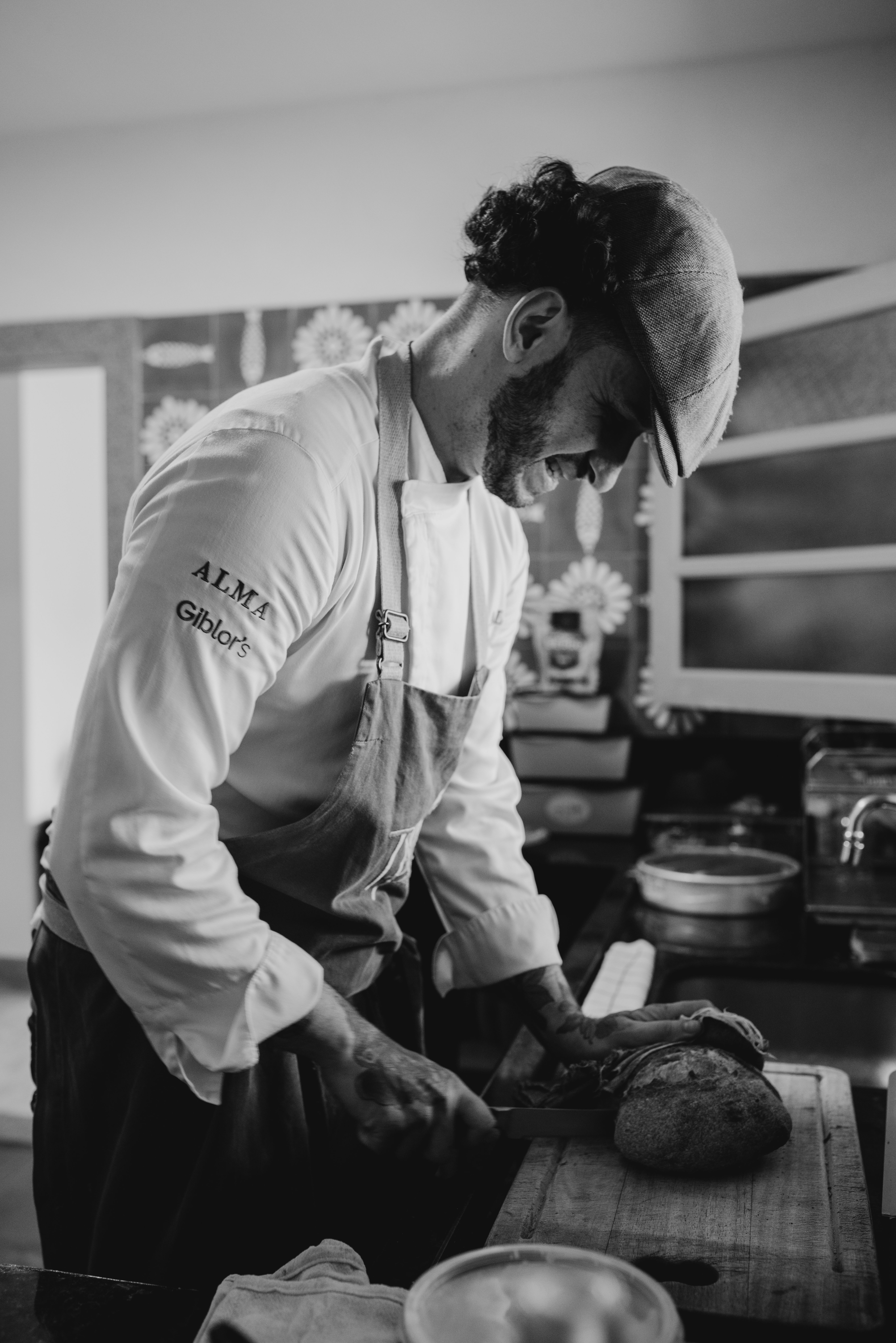 Artisan chef slicing homemade bread in kitchen · Free Stock Photo