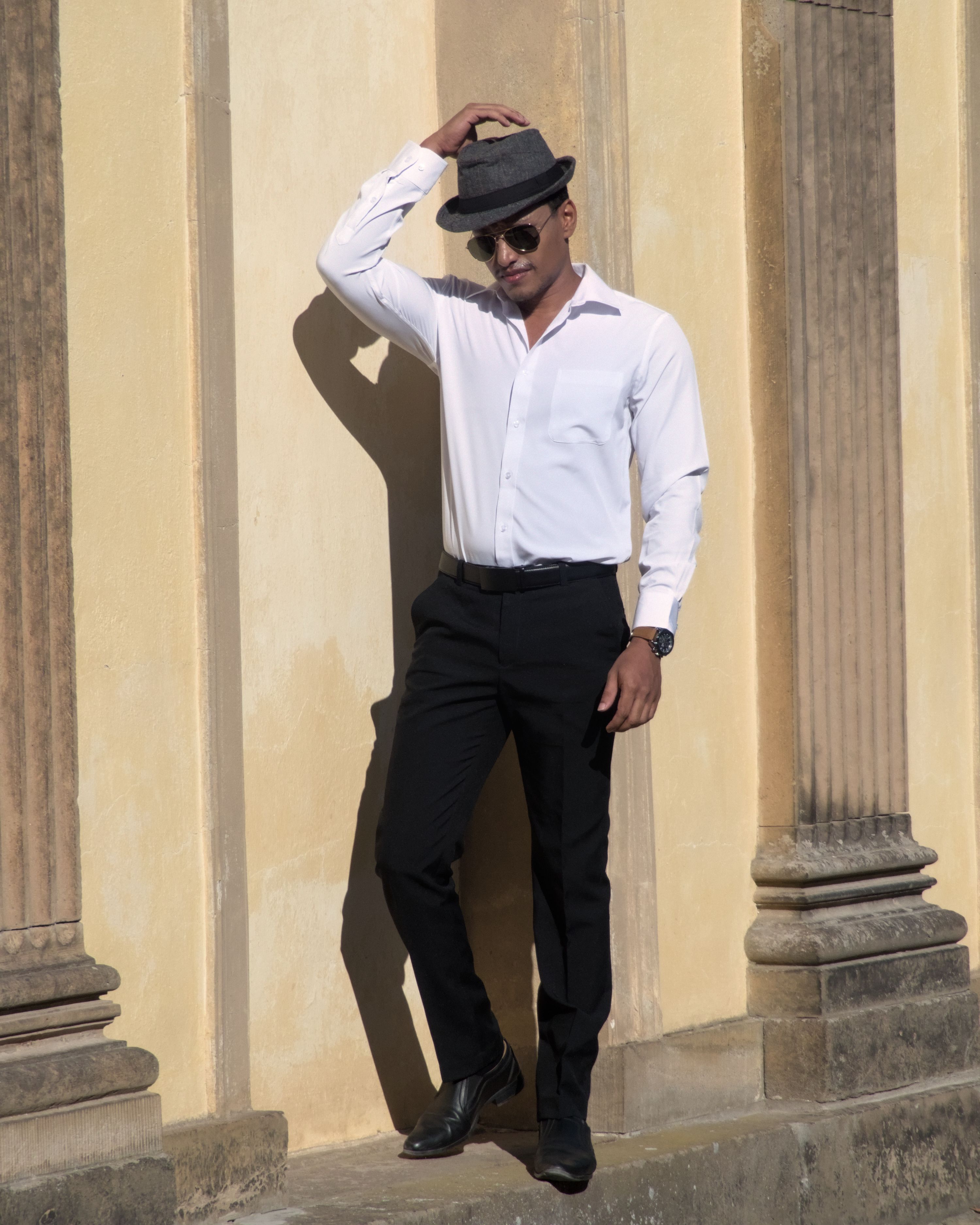 Stylish Man Posing Against Classical Architecture · Free Stock Photo