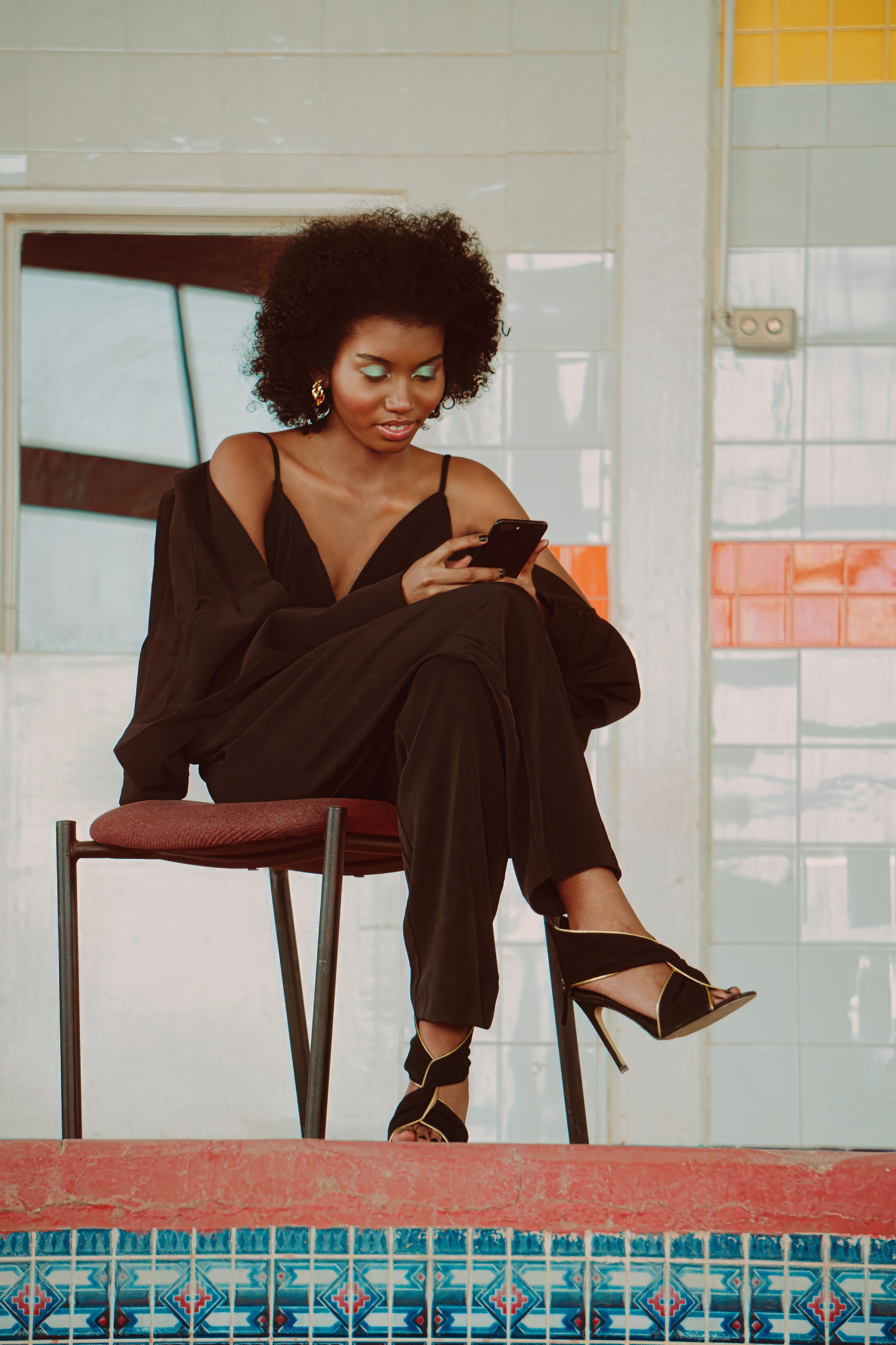Chic Woman with Smartphone in Modern Setting · Free Stock Photo