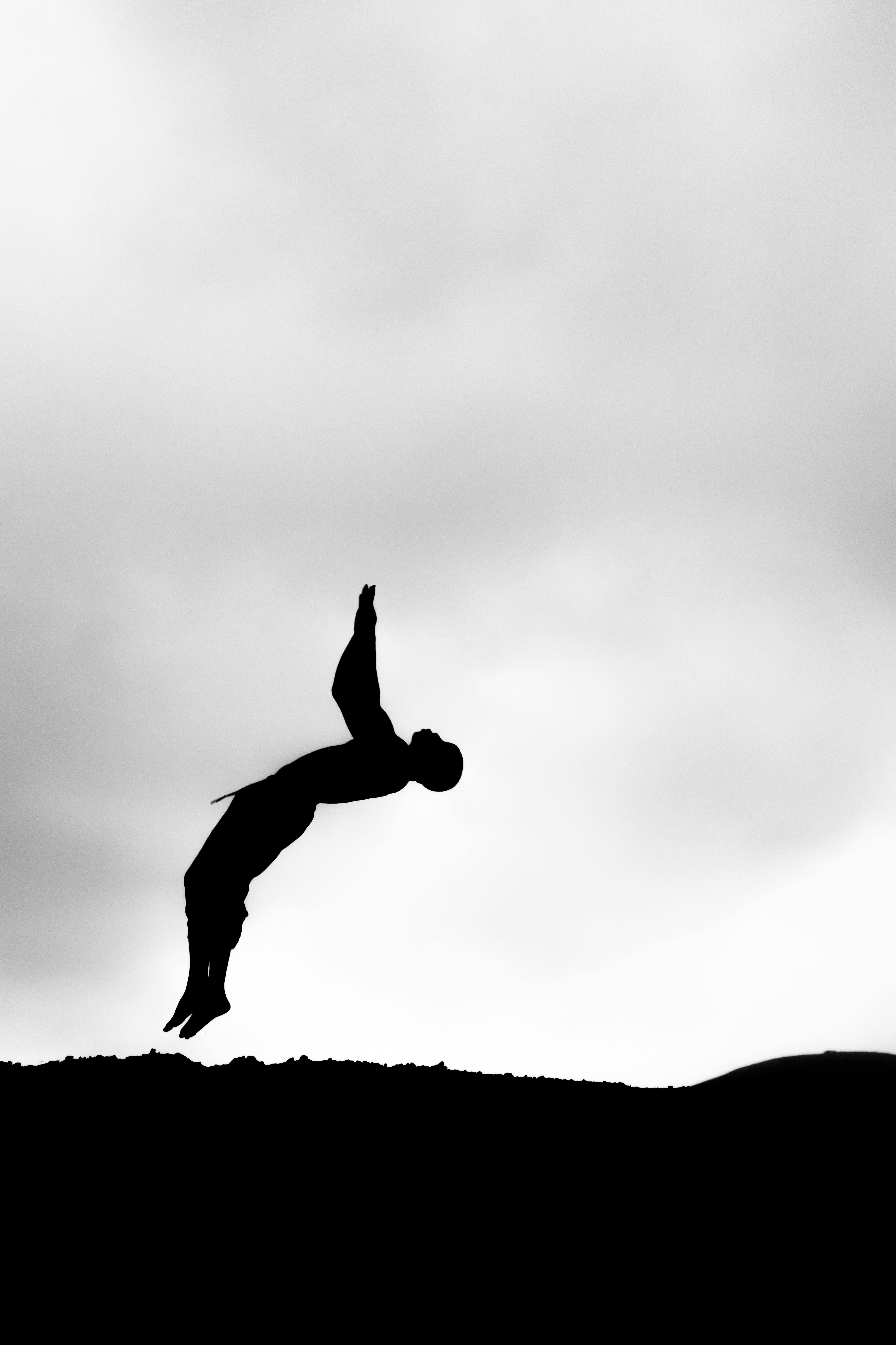 Silhouette of Man in Mid-Air Backflip Against Sky · Free Stock Photo