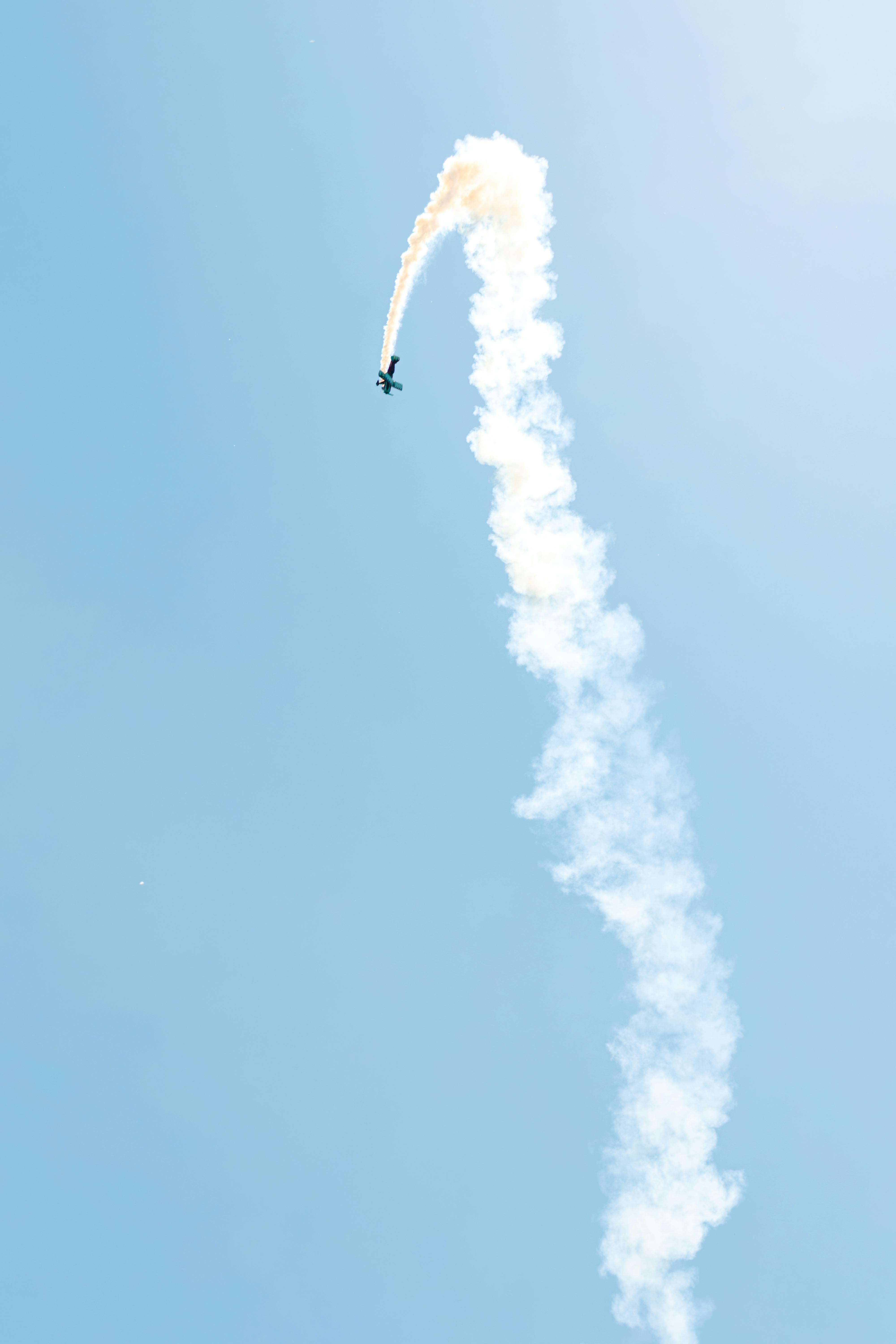 High-Speed Jet Performing Aerial Stunt in Blue Sky · Free Stock Photo