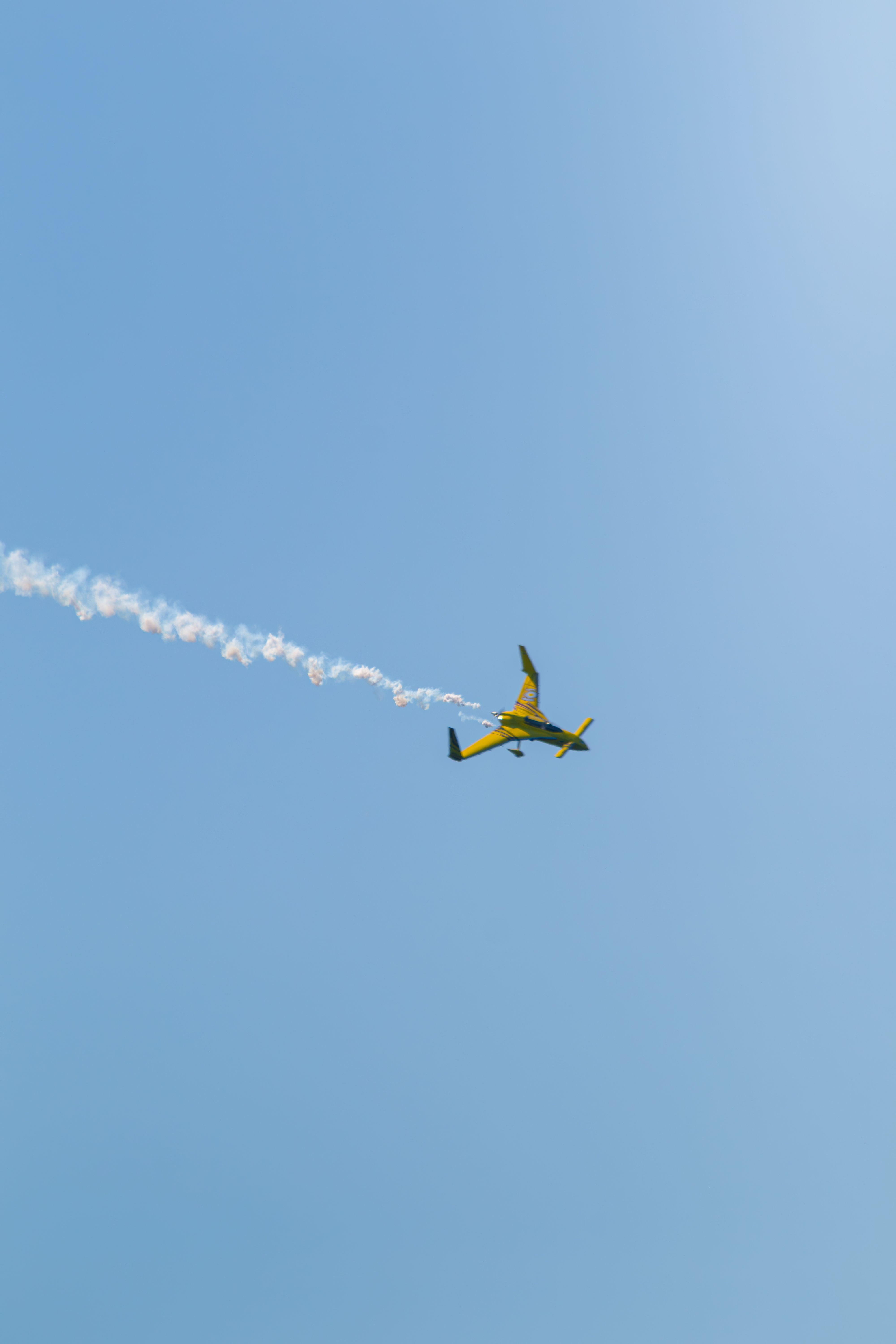 Yellow Stunt Plane Performing Aerobatics in Clear Sky · Free Stock Photo