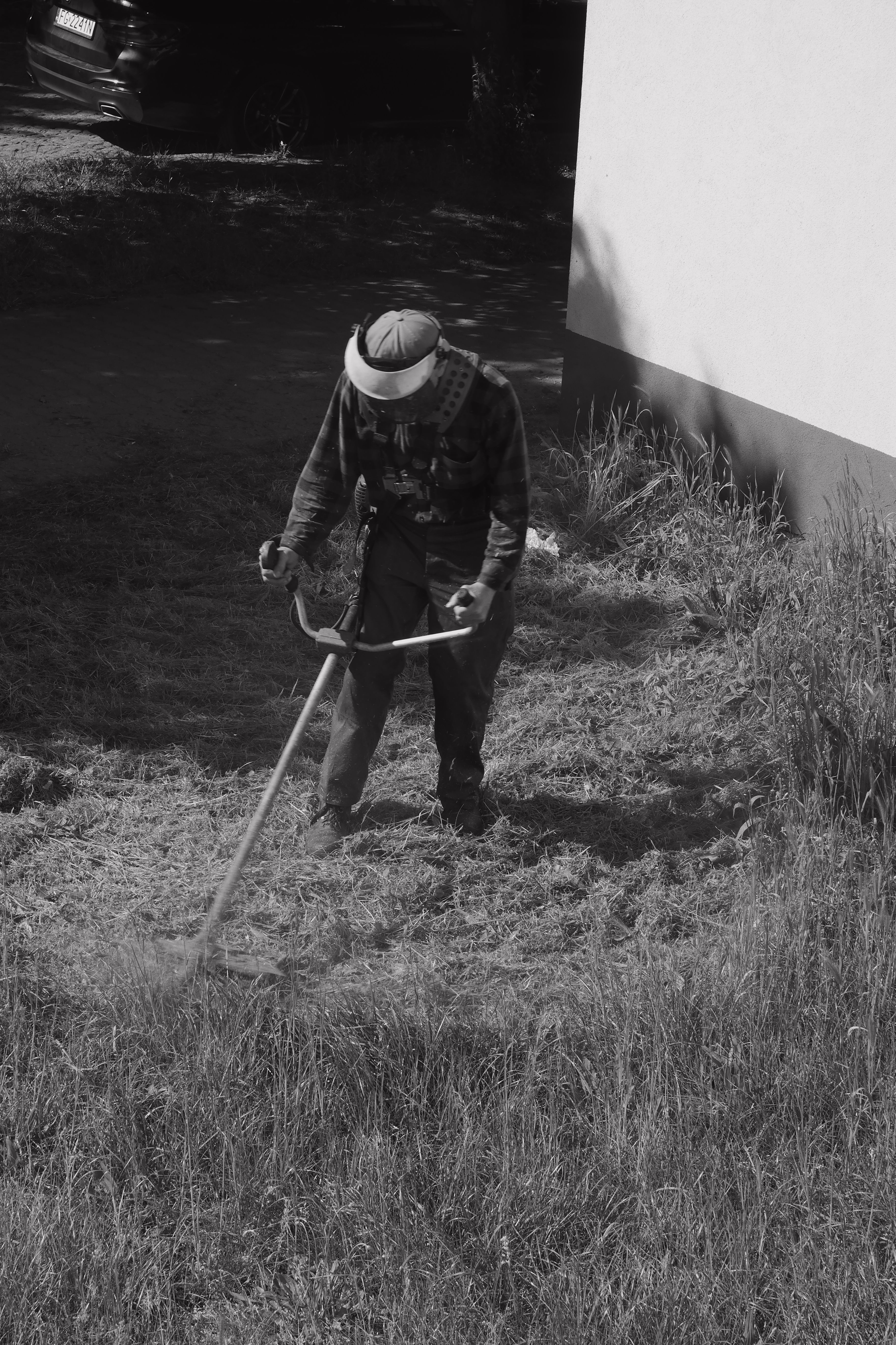 Gardener Using Weed Eater to Trim Grass Outdoors · Free Stock Photo