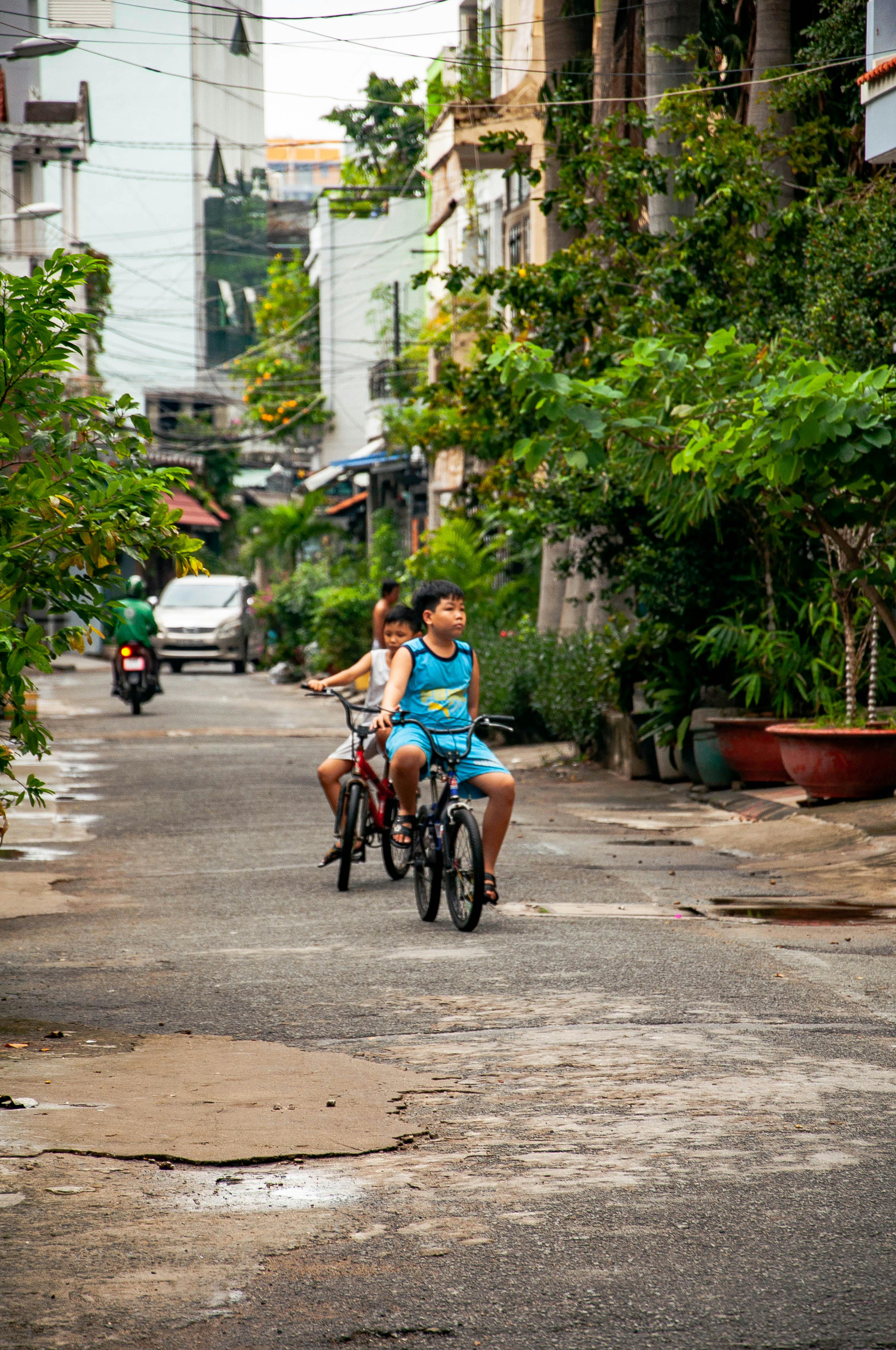Photo of Two Boys Riding Bikes on the Street · Free Stock Photo