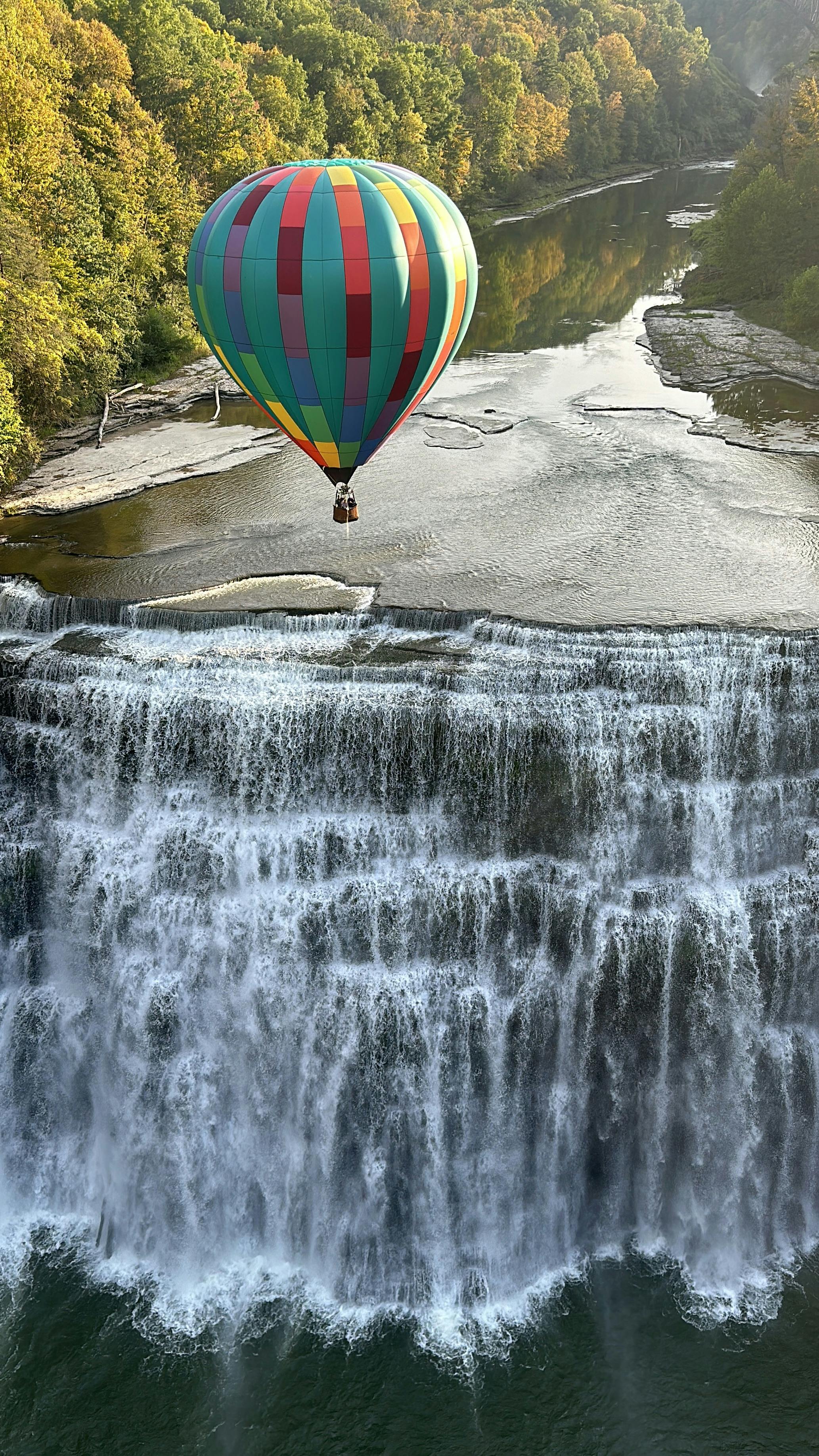 Colorful Hot Air Balloon Over Majestic Waterfall · Free Stock Photo